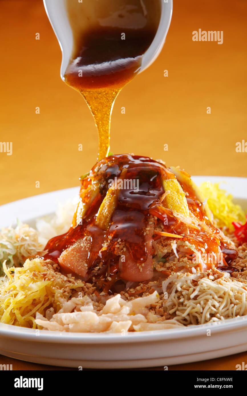 Pouring sauce on the yusheng Stock Photo - Alamy