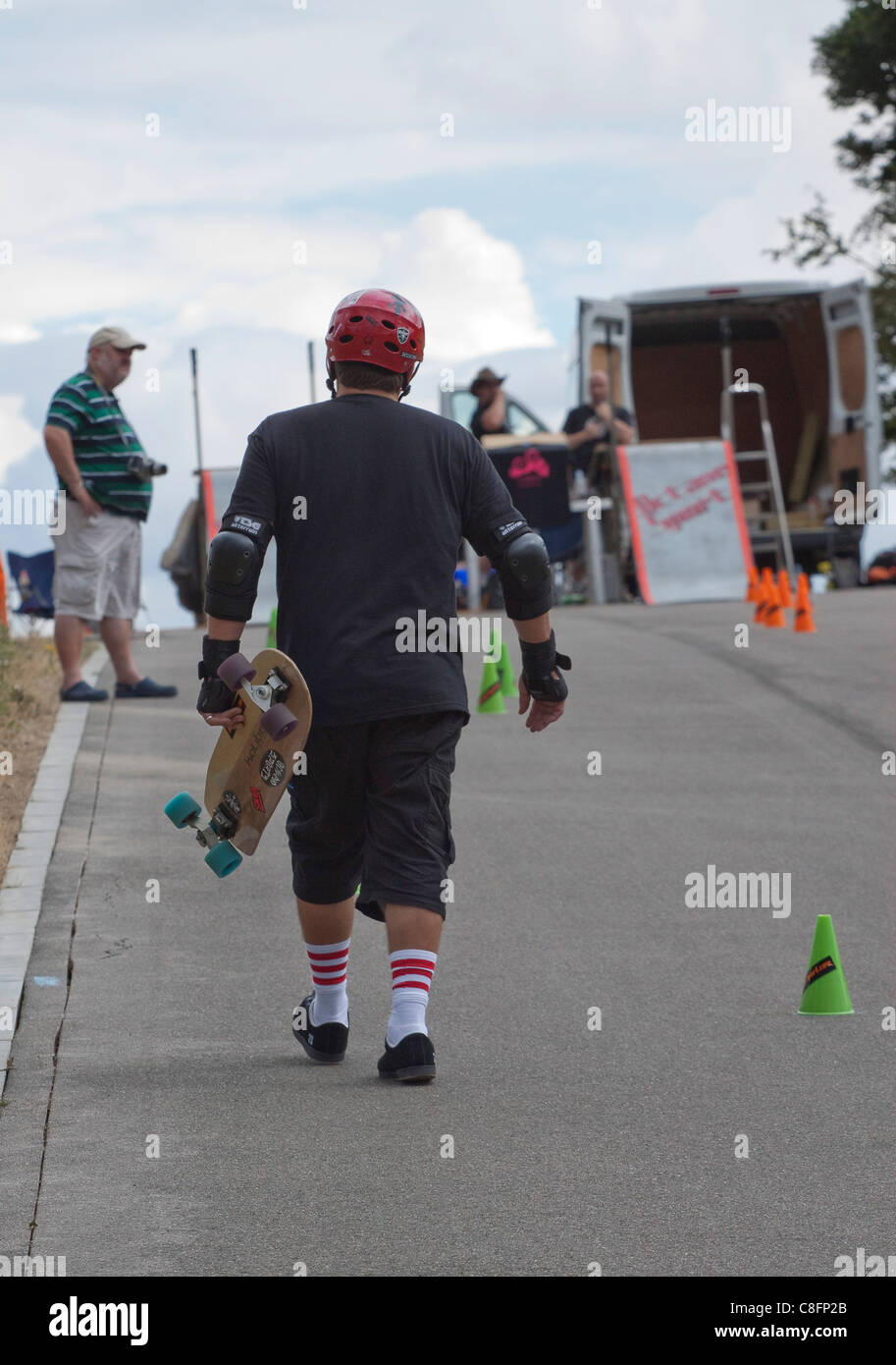 Slalom skateboarder at the UK slalom championship walking back up hill ...