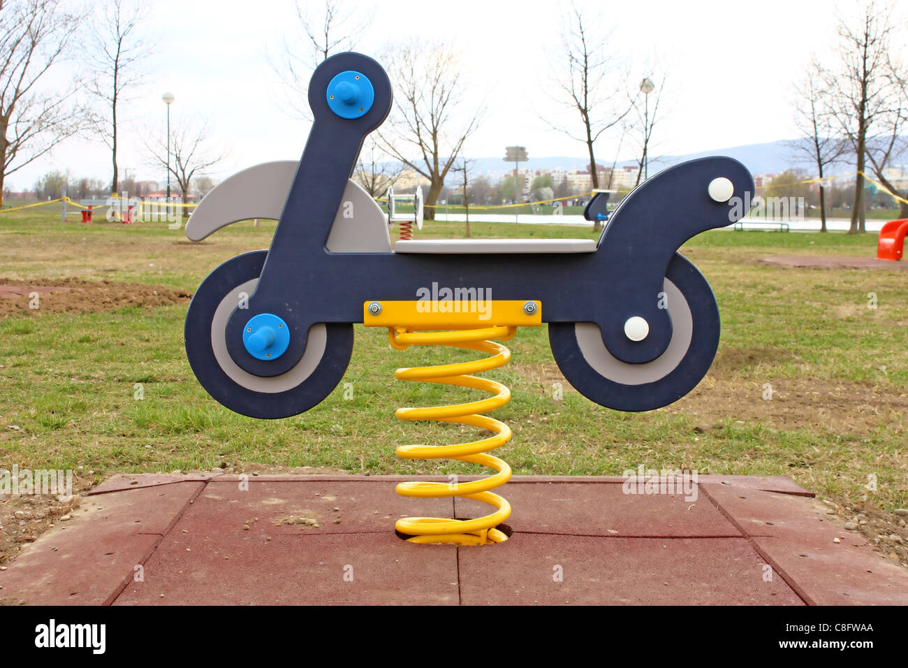 Motorbike spring swing toy in a playground Stock Photo - Alamy
