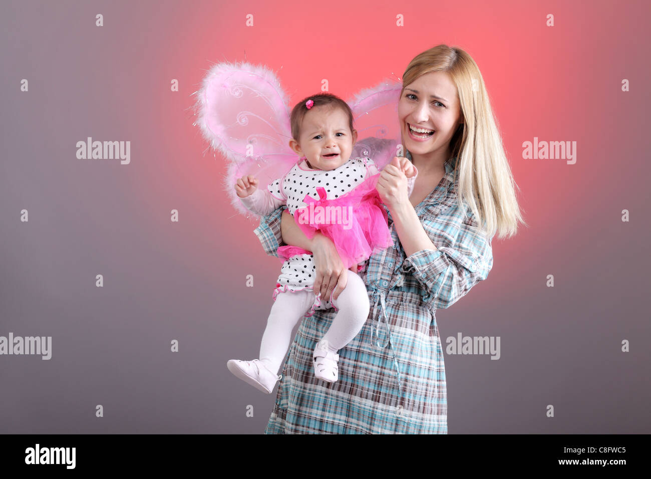 mother and daughter with funny expressions on pink background Stock ...