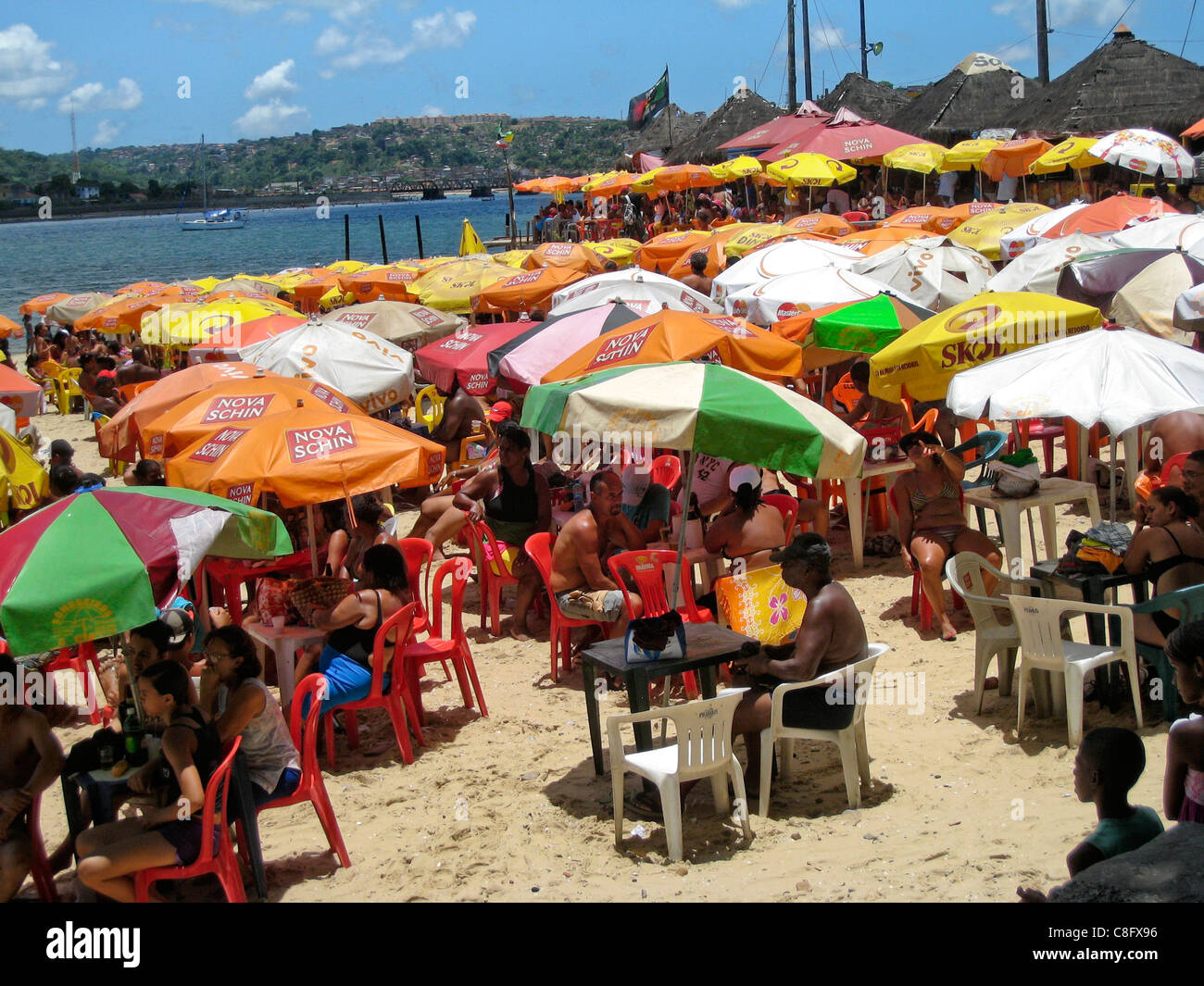 Beach activity on busy holiday, bathers and colourful umbrellas ...