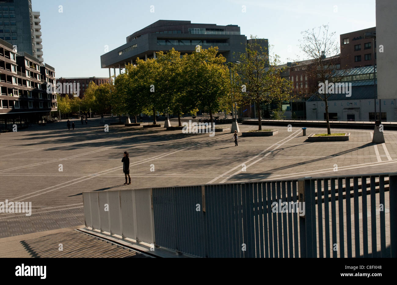 Almost empty square with young woman standing in square Stock Photo - Alamy