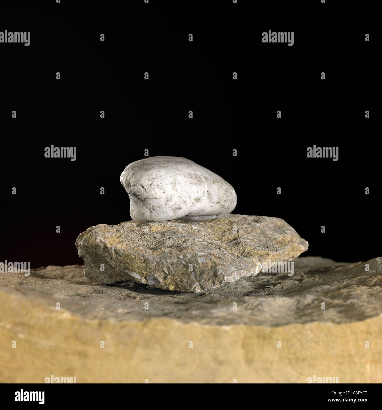 small stone pile in front of dark back Stock Photo - Alamy