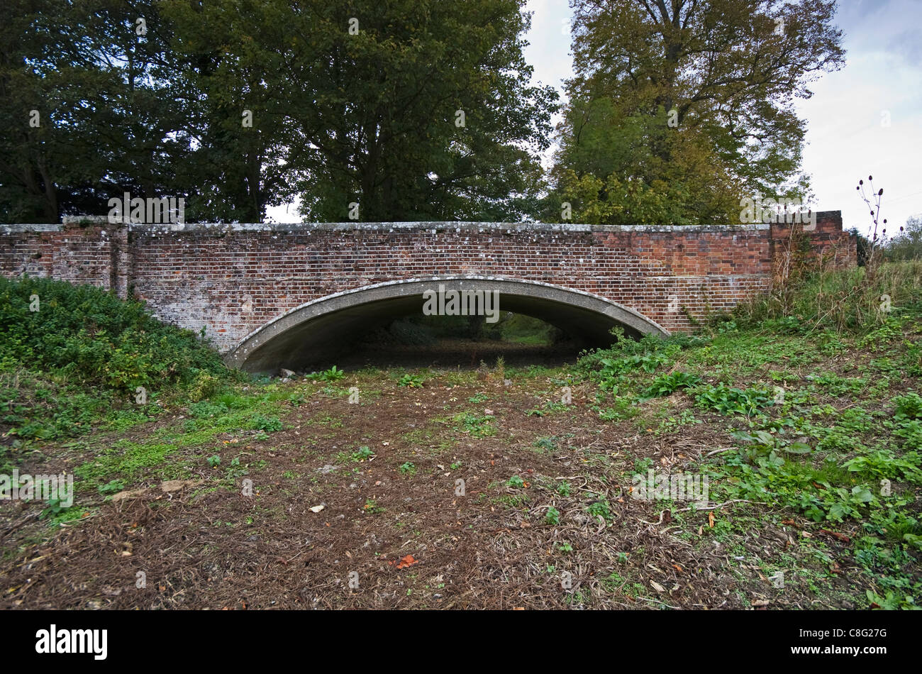 A dry river in Autumn showing cracked mud. The bridge gives an idea of ...