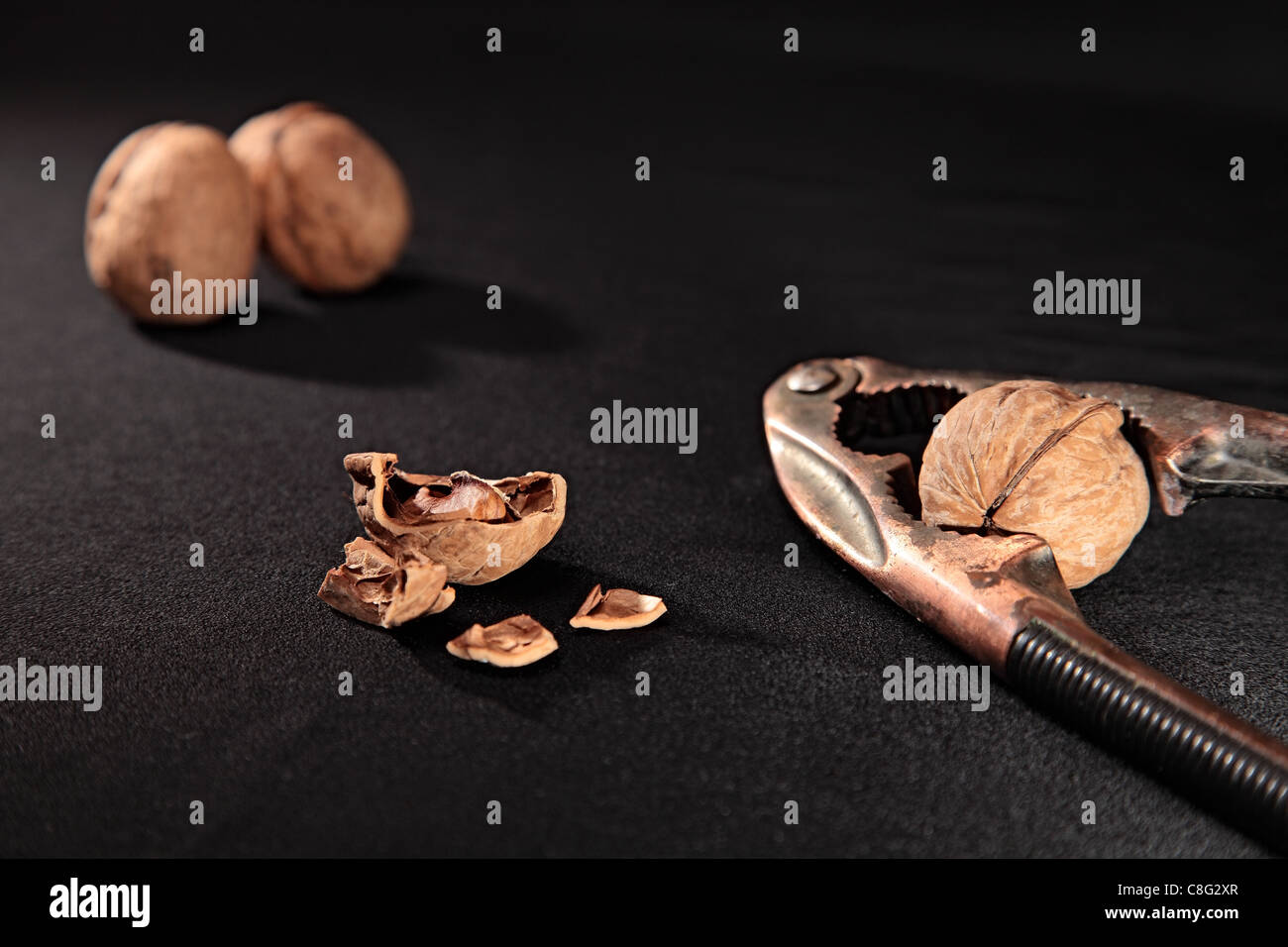 nutcracker, whole and chopped nuts on black background Stock Photo - Alamy