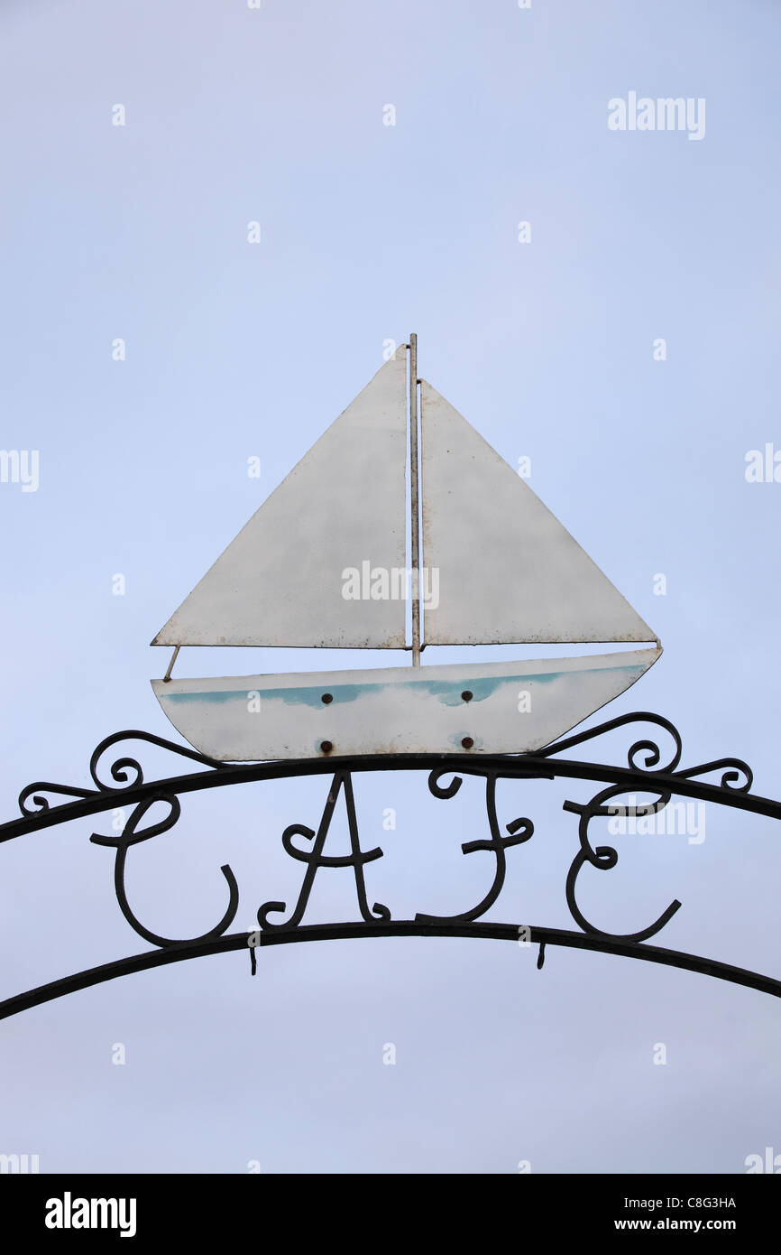 Ornate wrought iron sign "CAFE", with white yacht above, Southwold ...