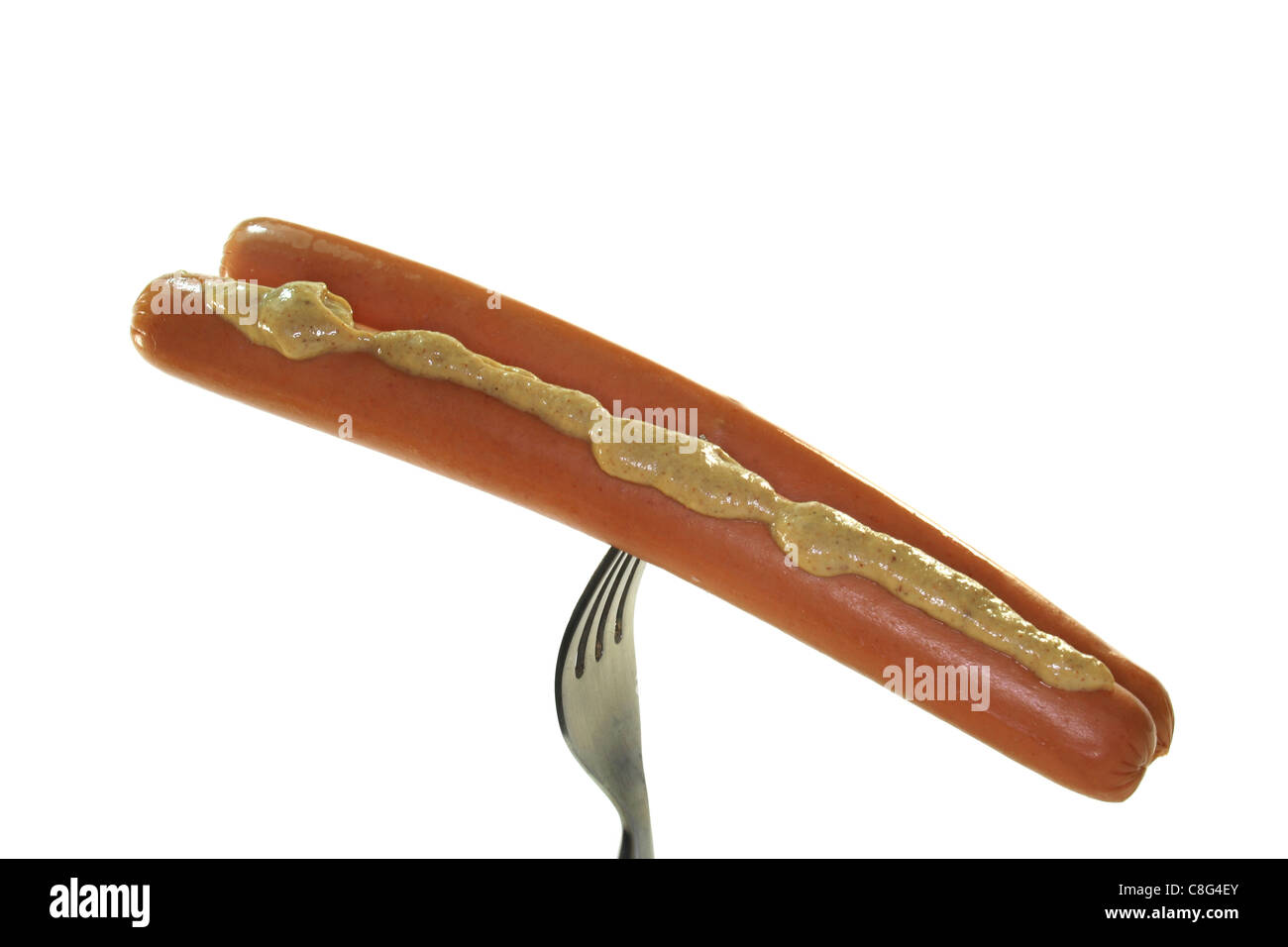 Wieners with mustard on a fork on a white background Stock Photo - Alamy