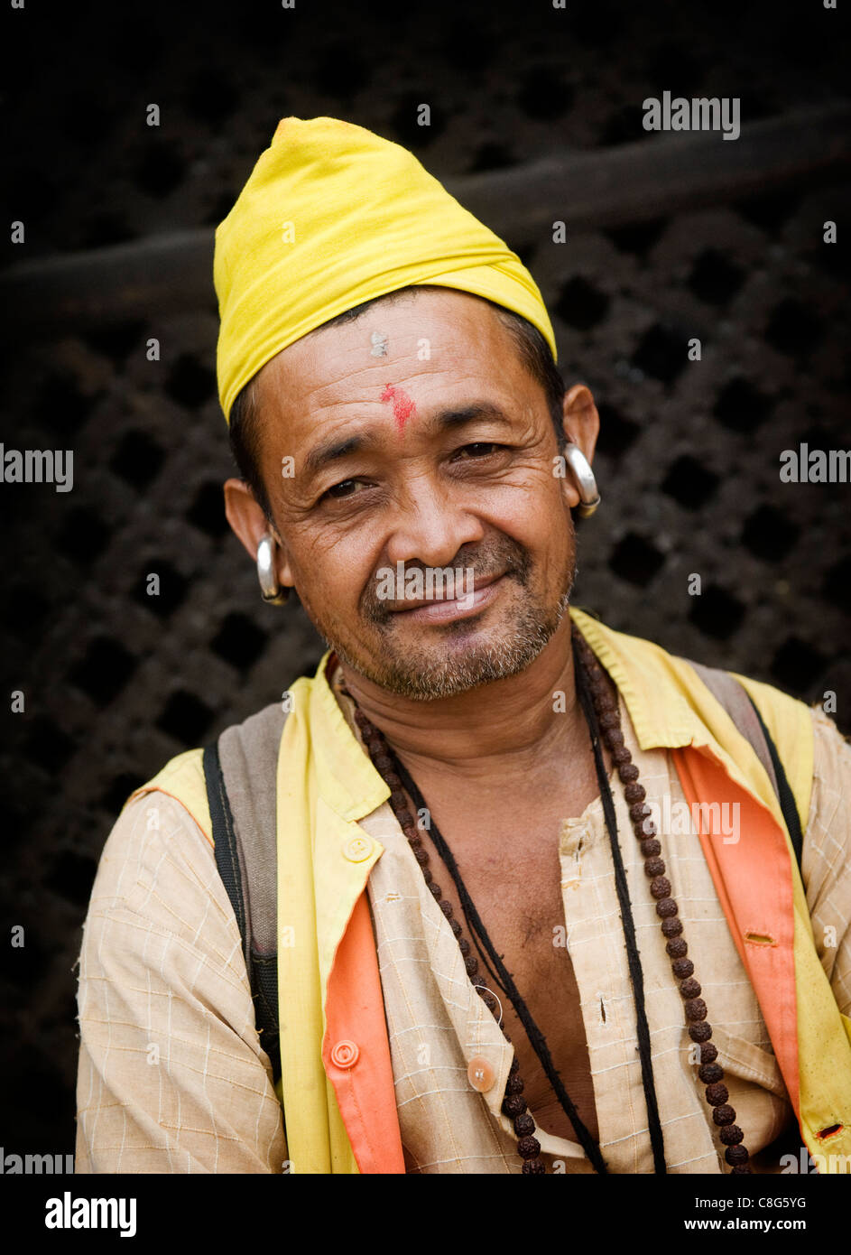 A local man wearing a yellow topi poses for the camera at Gorkha Durbar ...