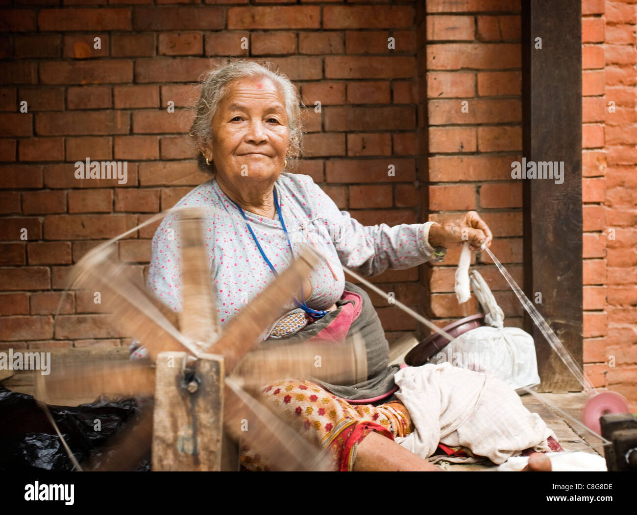 A local woman weaving using traditional methods on a street in ...