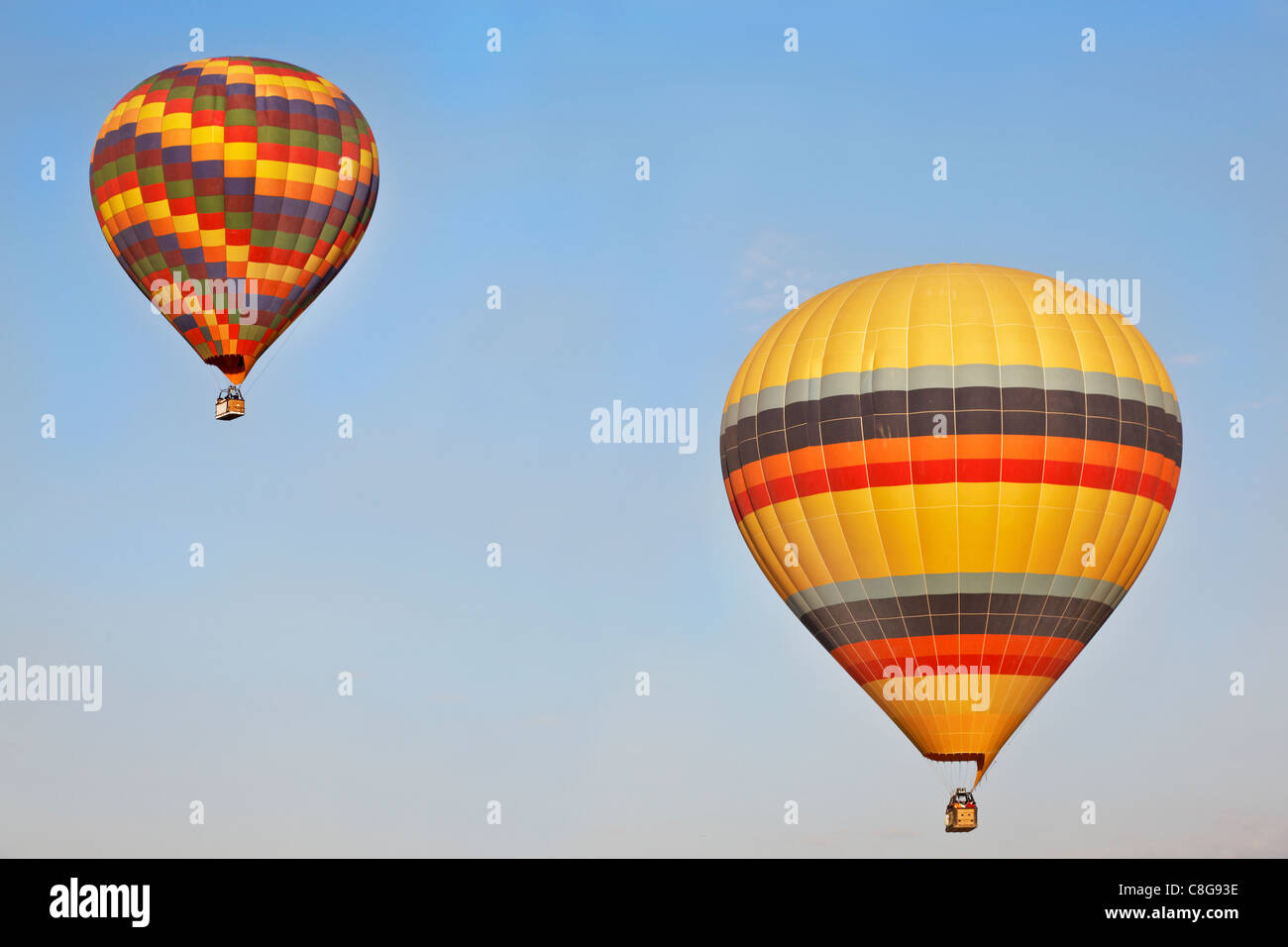 horizontal landscape of two colorful hot air balloons high in a light ...