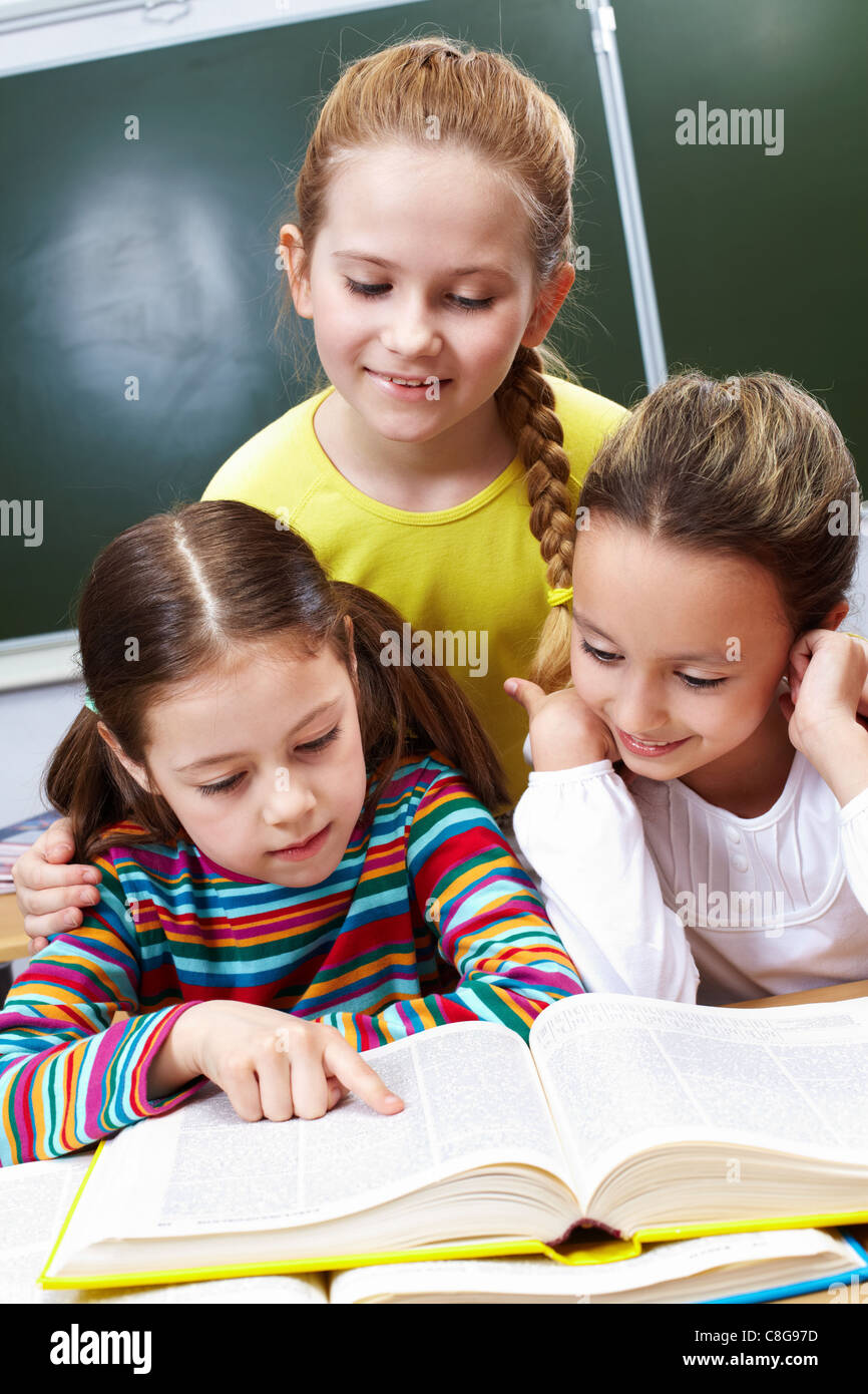 Portrait of friendly group reading book in classroom Stock Photo - Alamy