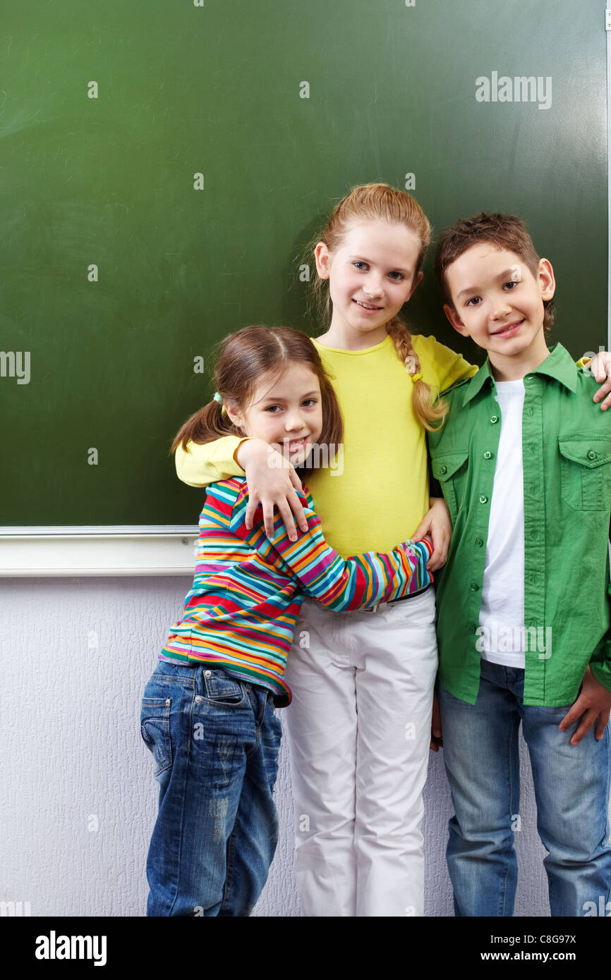 Group of happy classmates looking at camera by whiteboard Stock Photo ...