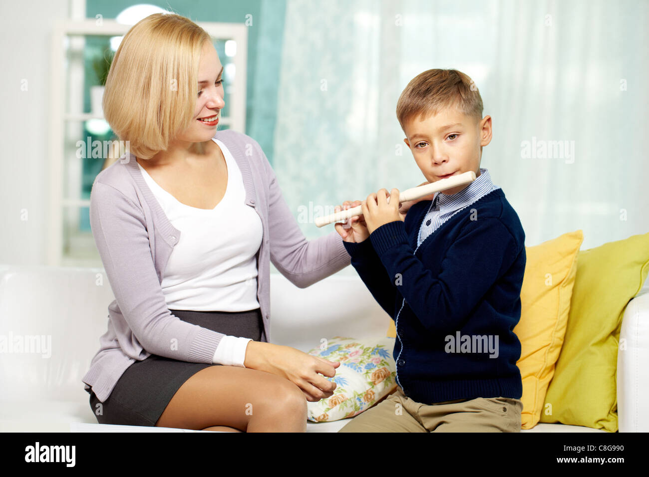 Portrait of pretty tutor looking at her diligent pupil playing the ...