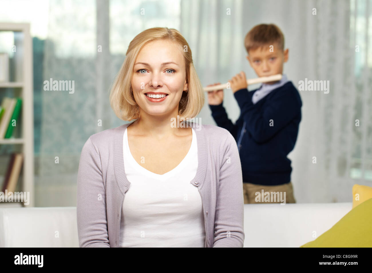 Portrait of happy tutor looking at camera on background of pupil ...