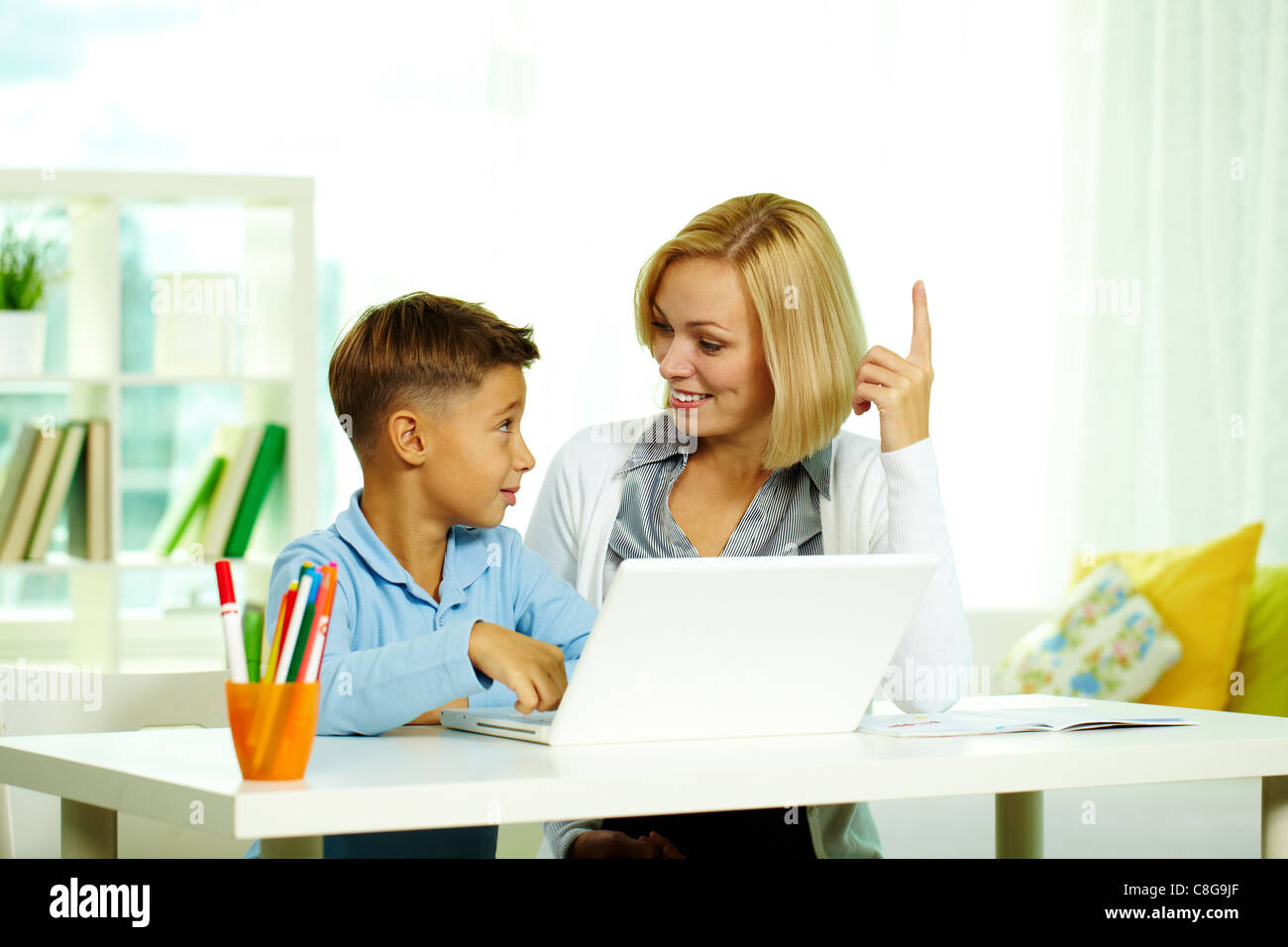 Portrait of pretty tutor and diligent pupil discussing ideas while ...