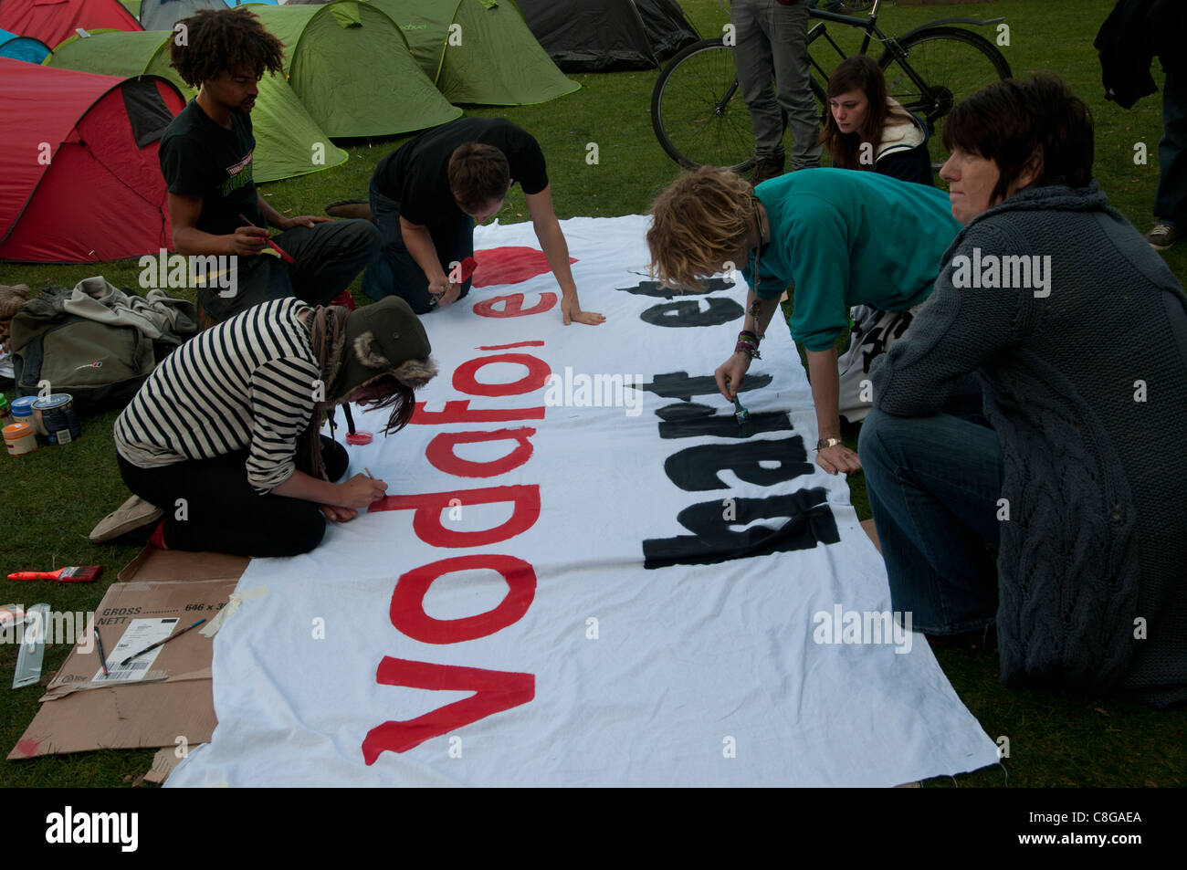 Members of the camp make a banner calling for the resignation of David ...