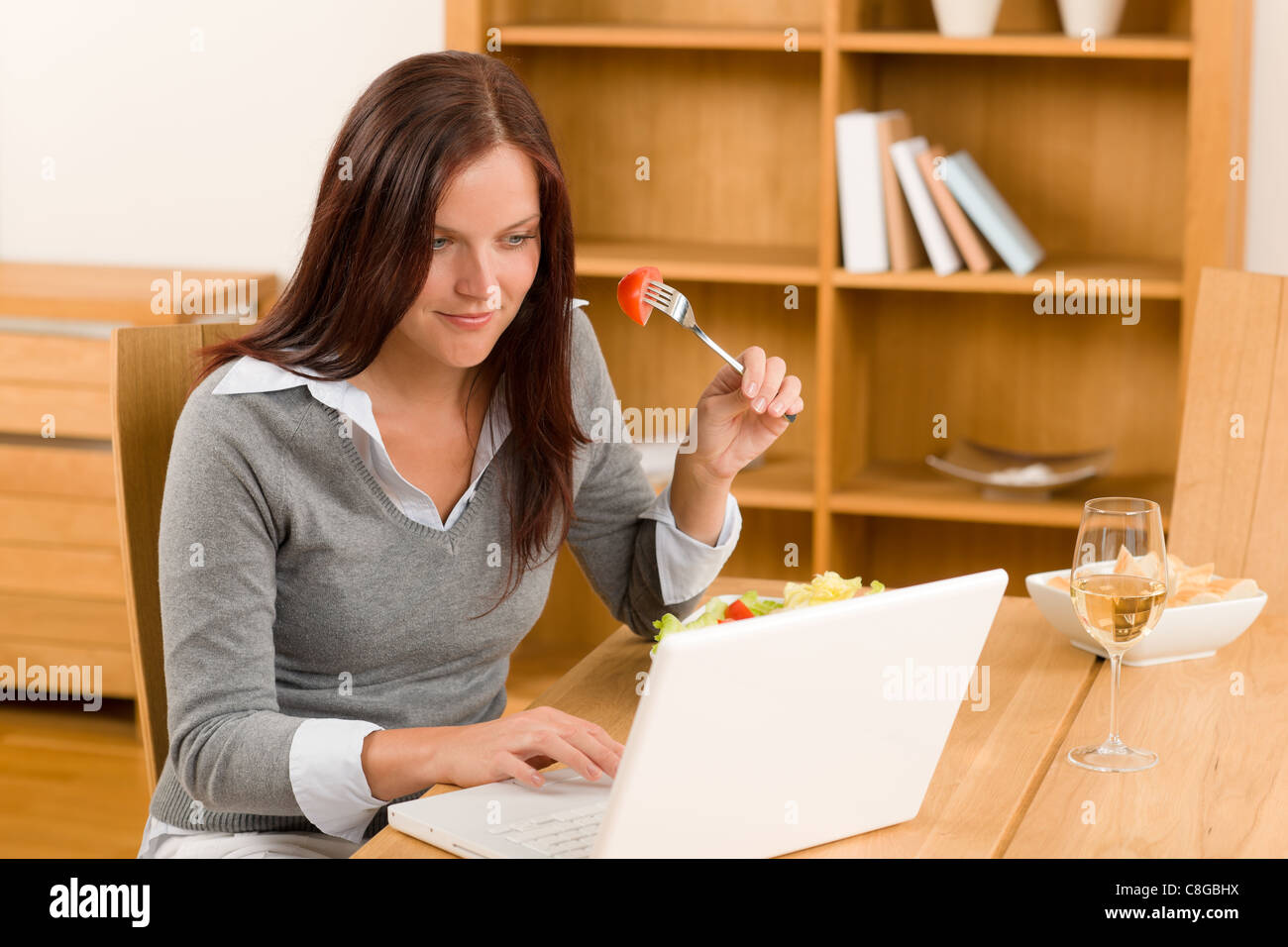 Working lunch at home attractive woman with laptop eat salad Stock ...
