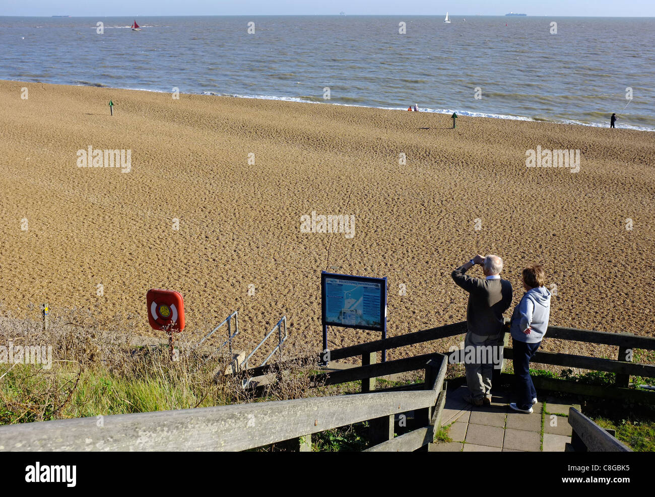 Two people looking out over a beach at Felixstowe Stock Photo - Alamy