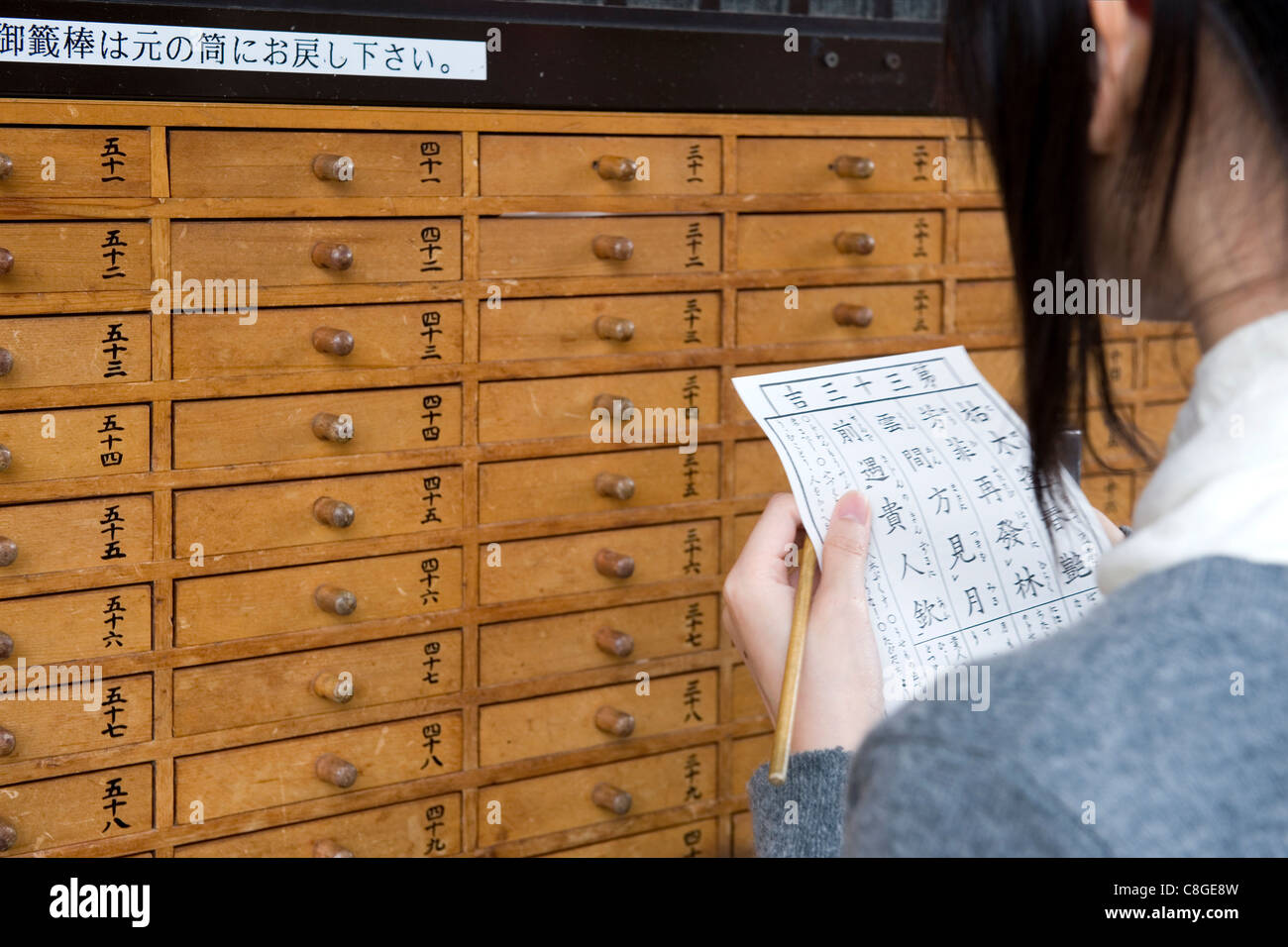 A girl reads her omikuji (paper oracle) at Sensoji Temple in Asakusa ...