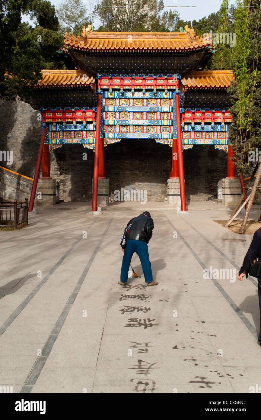 Man doing traditional water calligraphy next to Archway of Zhishan ...