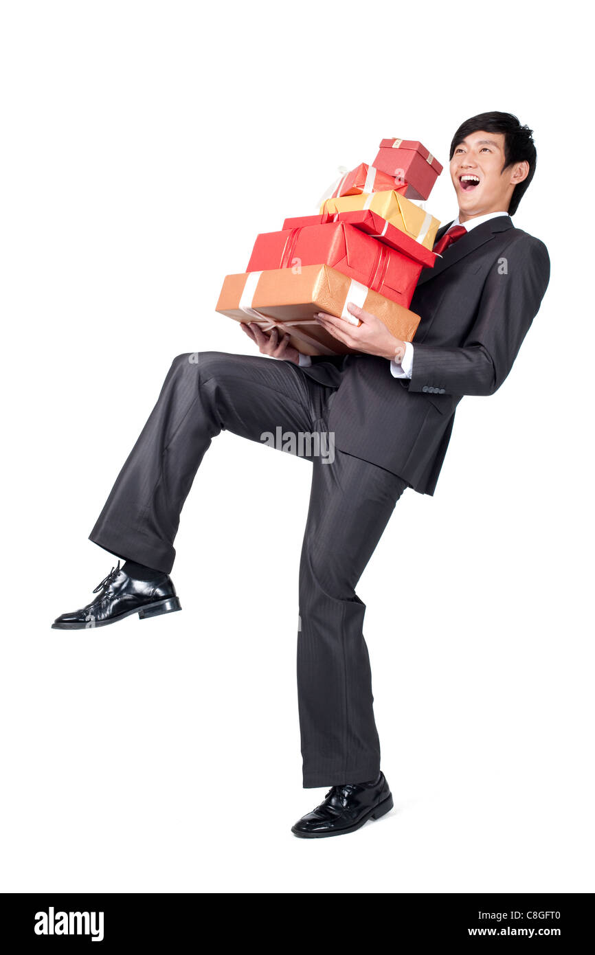 Excited Businessman Holding a Stack of Gifts Stock Photo - Alamy