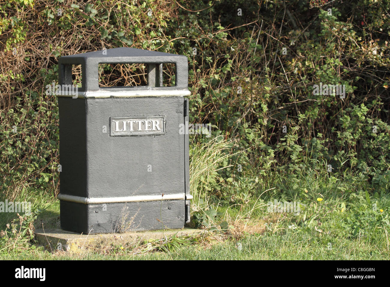 litter bin at the side of a road with bushes Stock Photo - Alamy