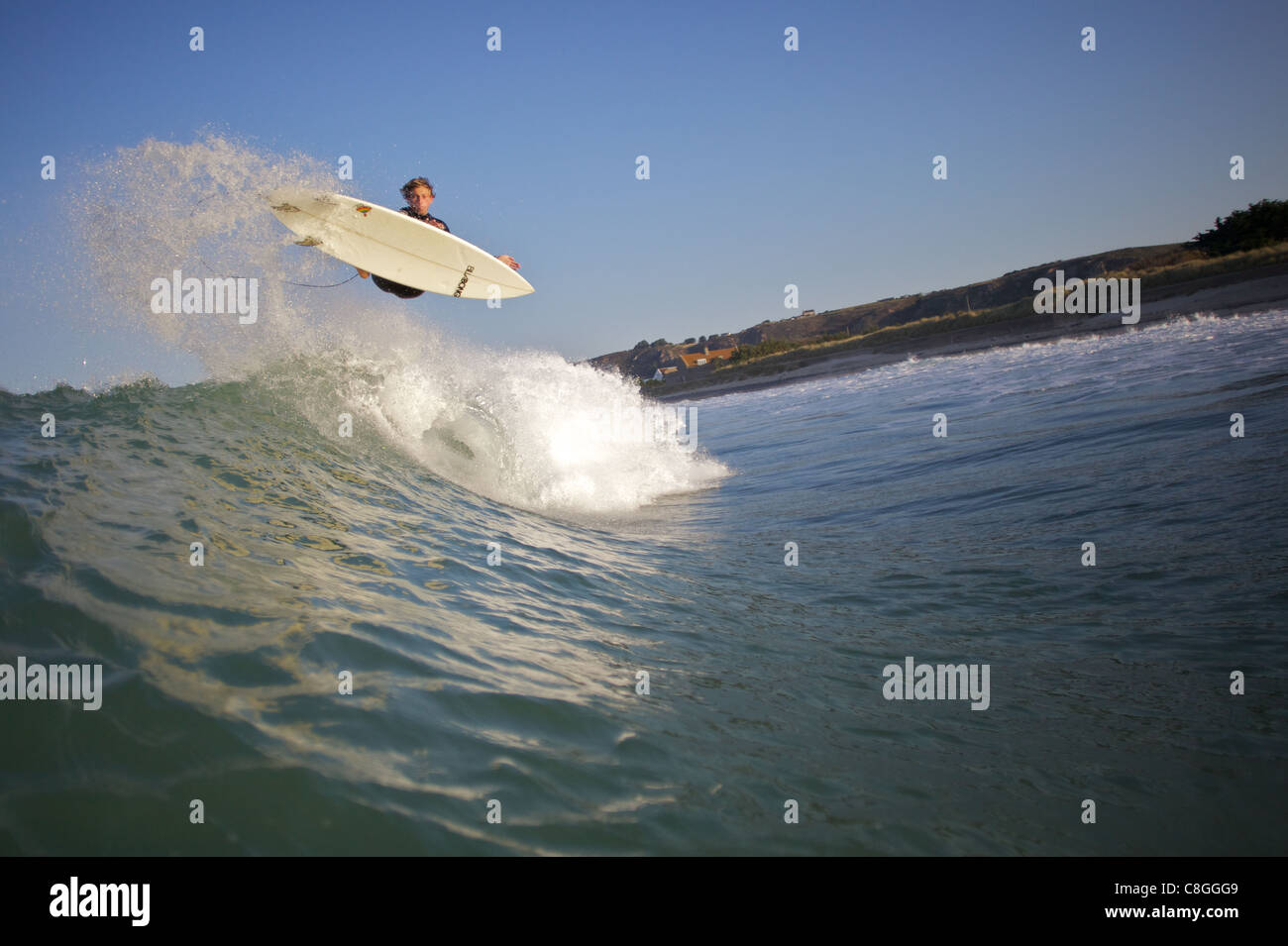 surfer getting huge air on a reverse air on a sunny, clean wave Stock ...
