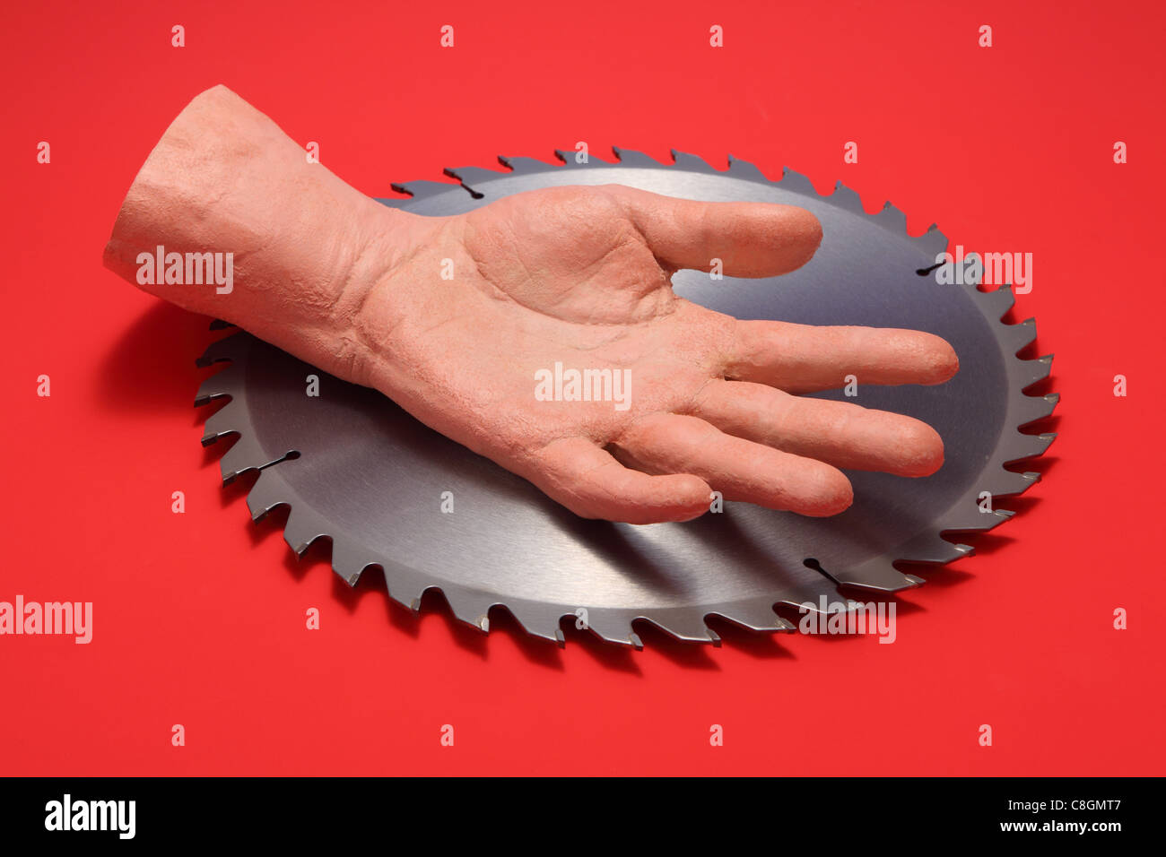 A fake human hand resting in the middle of a metal circular saw blade ...
