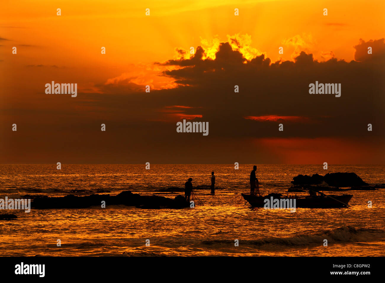 Fishermen fishing in the Ionian sea around sunset, at the beach close ...