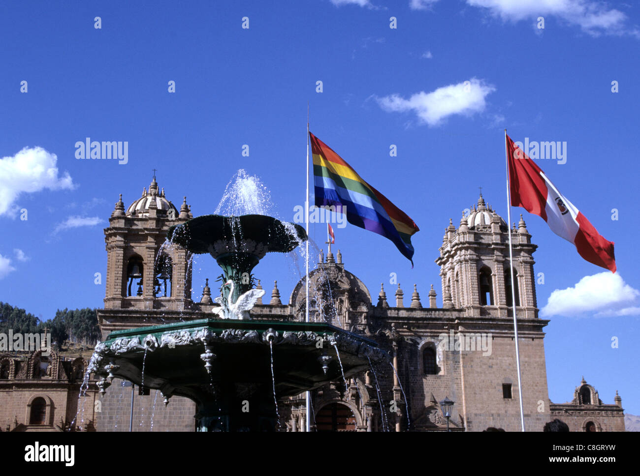 Cusco, Peru. Fountain in the Plaza de Armas with swans; rainbow flag of ...