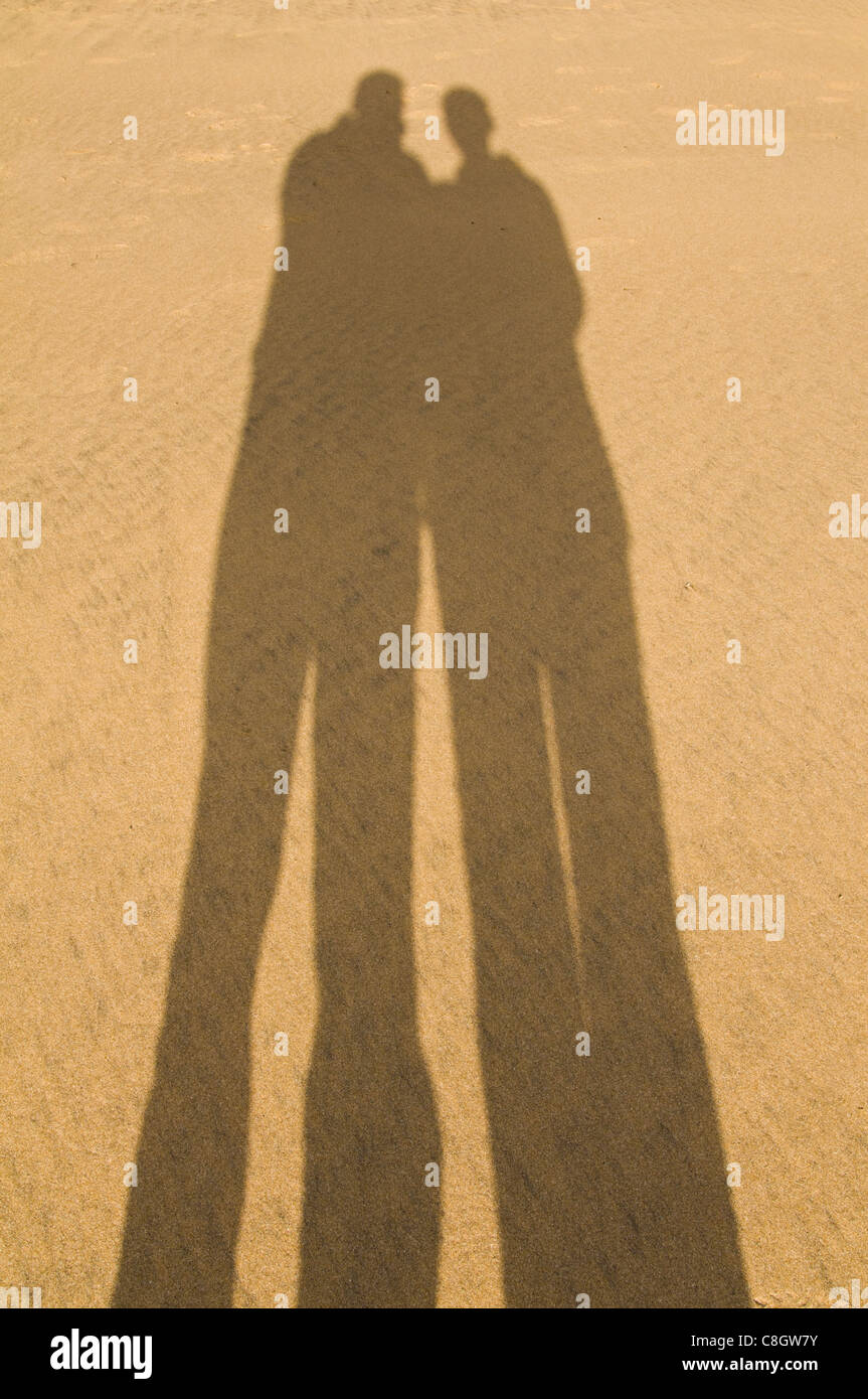 Shadow cast by a couple standing on the beach Stock Photo - Alamy