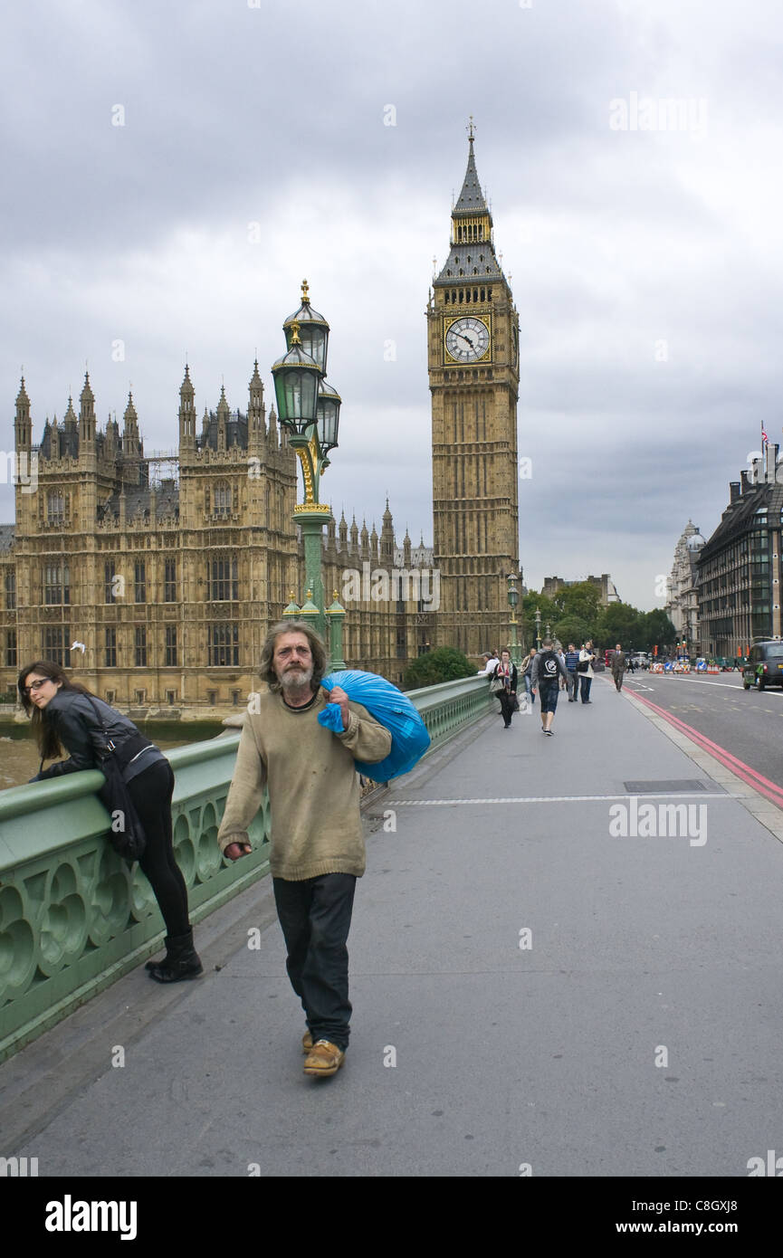 A man, possibly homeless, carries a bag across Westminster Bridge ...