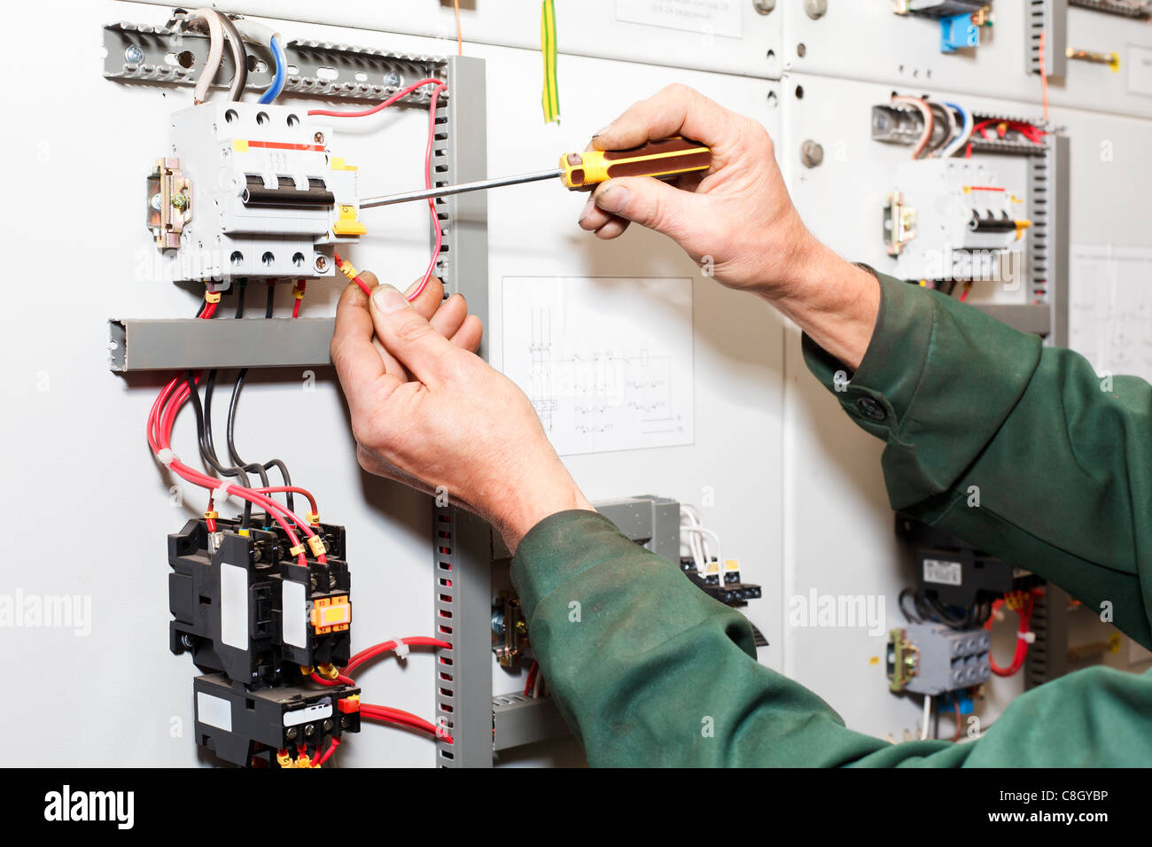 Electrician`s hands working with cables and wires. Screwdriver in hand ...