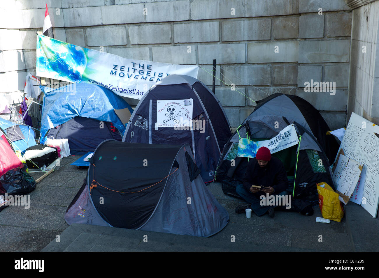 Protesters and tents with slogans and banners at the anti Capitalist ...
