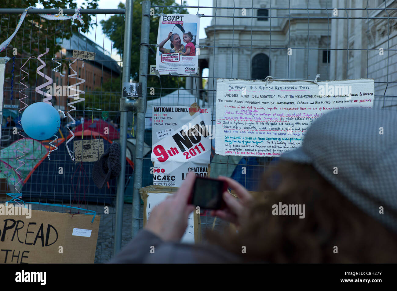 Tourist taking a photos of slogans and banners at the anti Capitalist ...