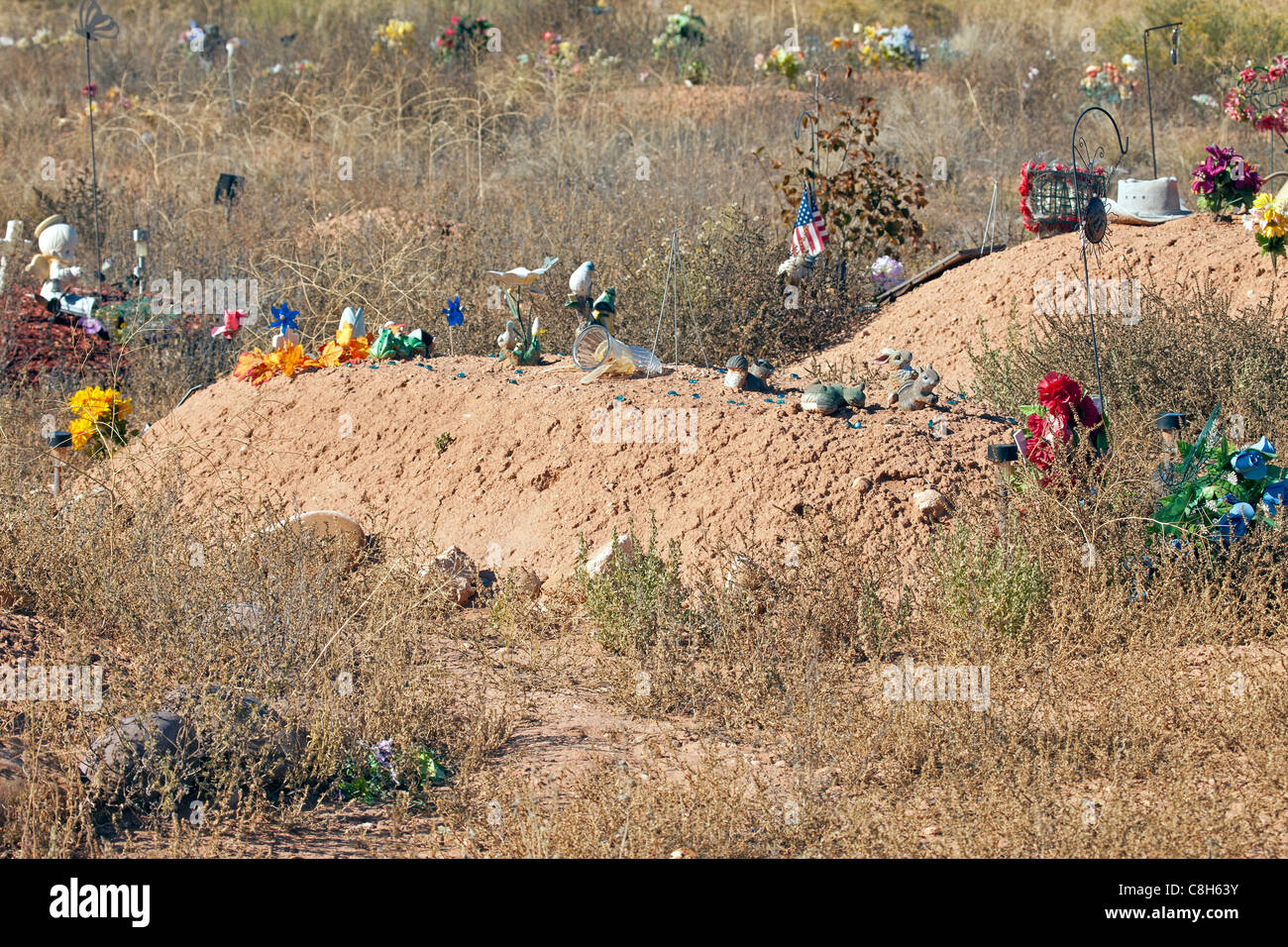 Cemetery neglected, overgrown with weeds with wooden post, plastic ...