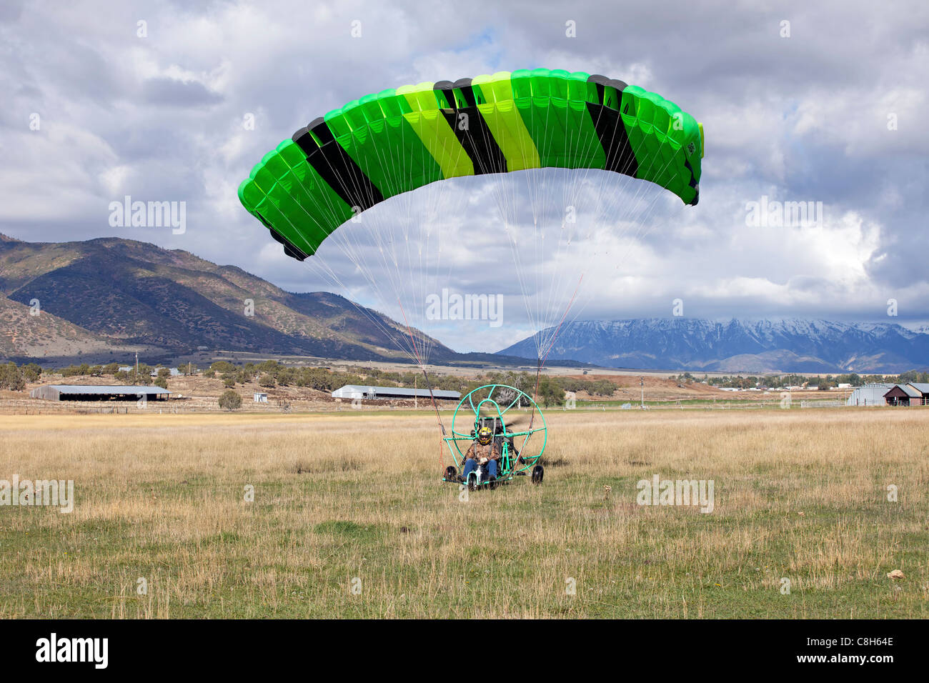 Powered parachute taking off by mountains. Small, low powered aircraft ...