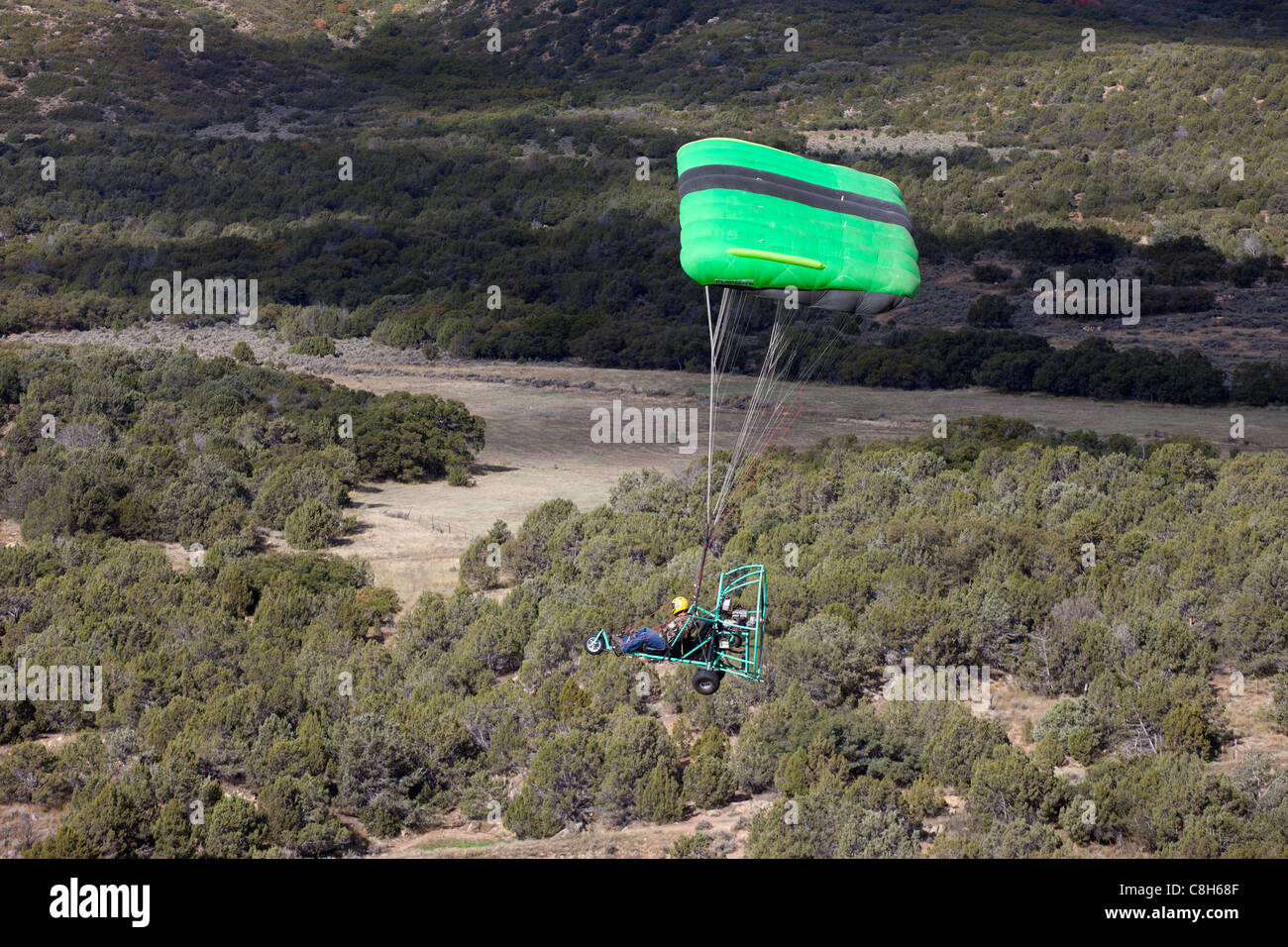 Powered parachute flying by mountains. Small, low powered aircraft ...