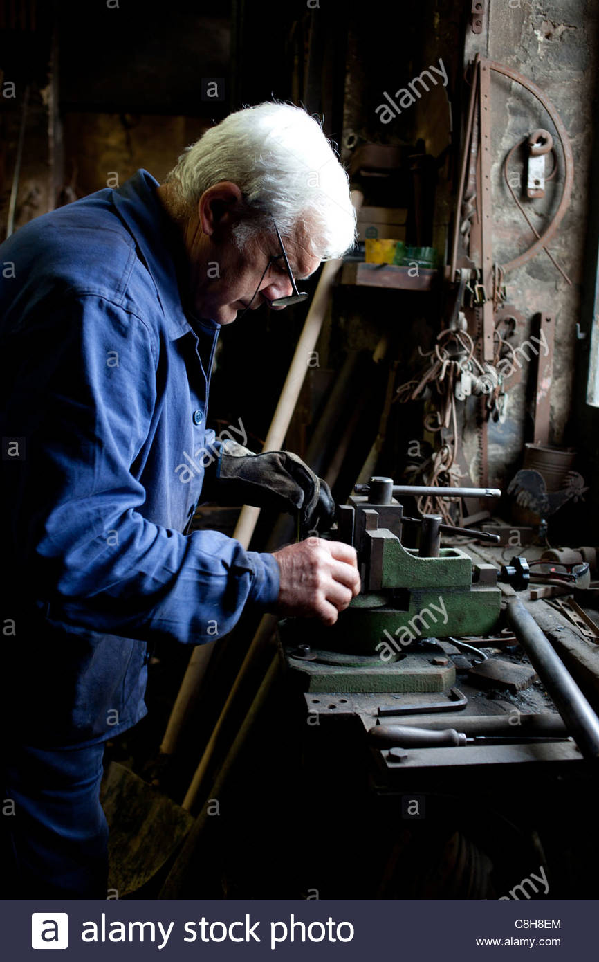 A Blacksmith works on a metal bending machine Stock Photo - Alamy