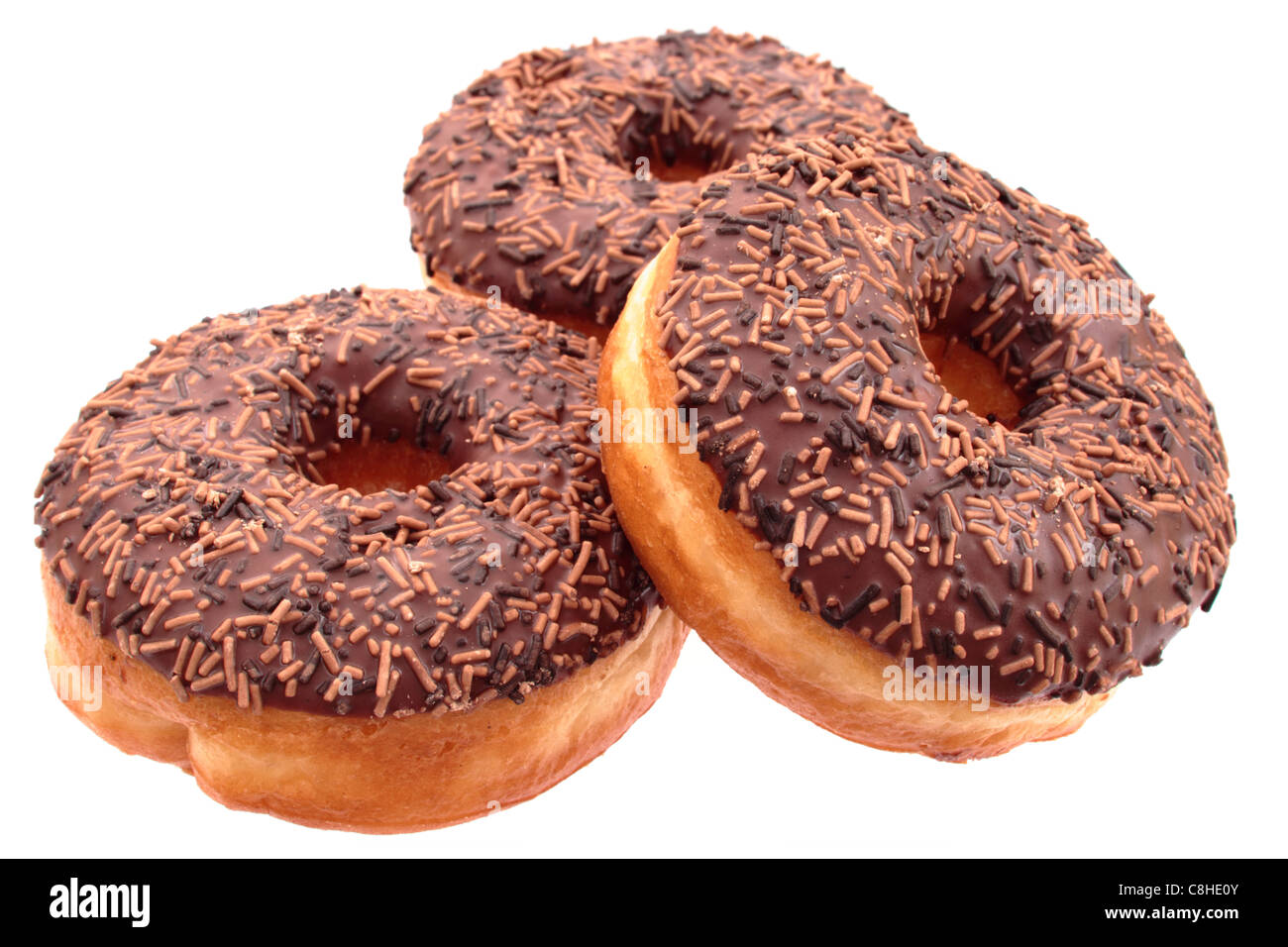 Three donuts with a chocolate topping isolated on a white background ...