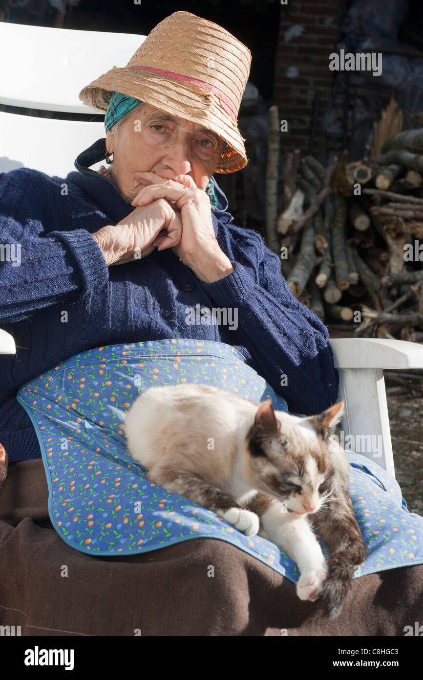senior woman sitting in the open with a siamese cat Stock Photo - Alamy