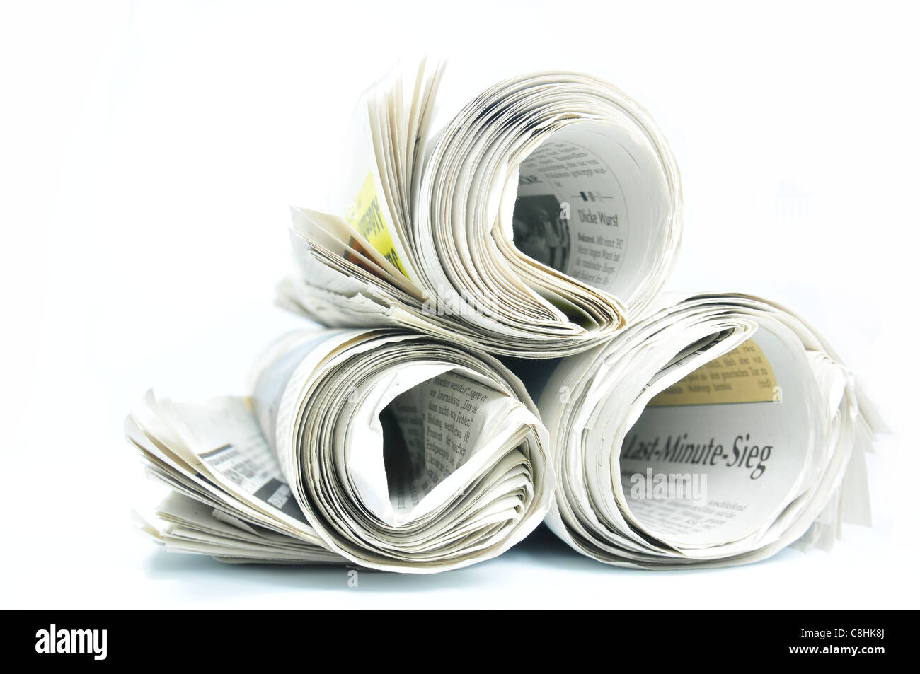 Three rolled up newspapers on white background Stock Photo - Alamy