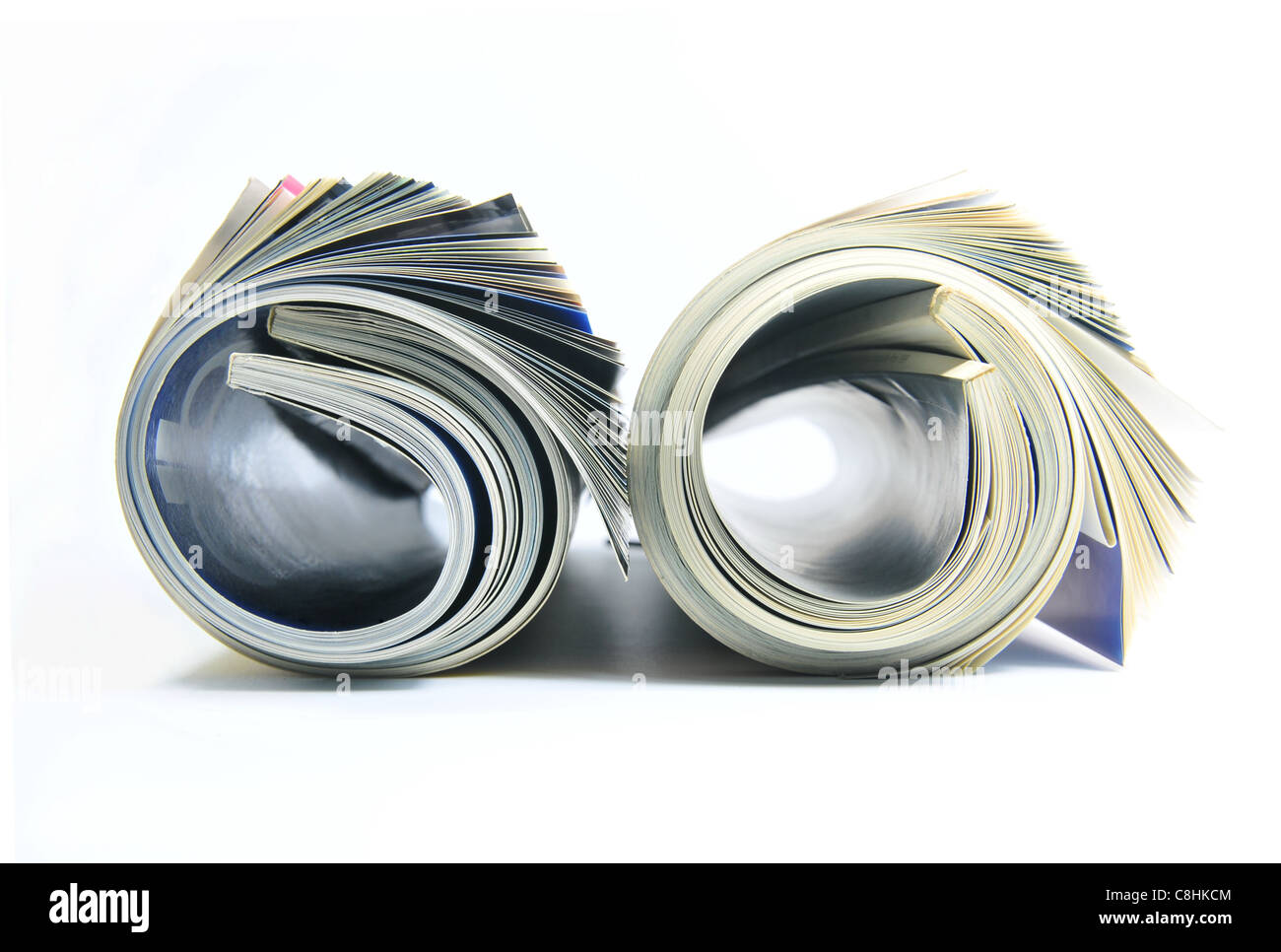 Two rolled up magazines on white background Stock Photo - Alamy