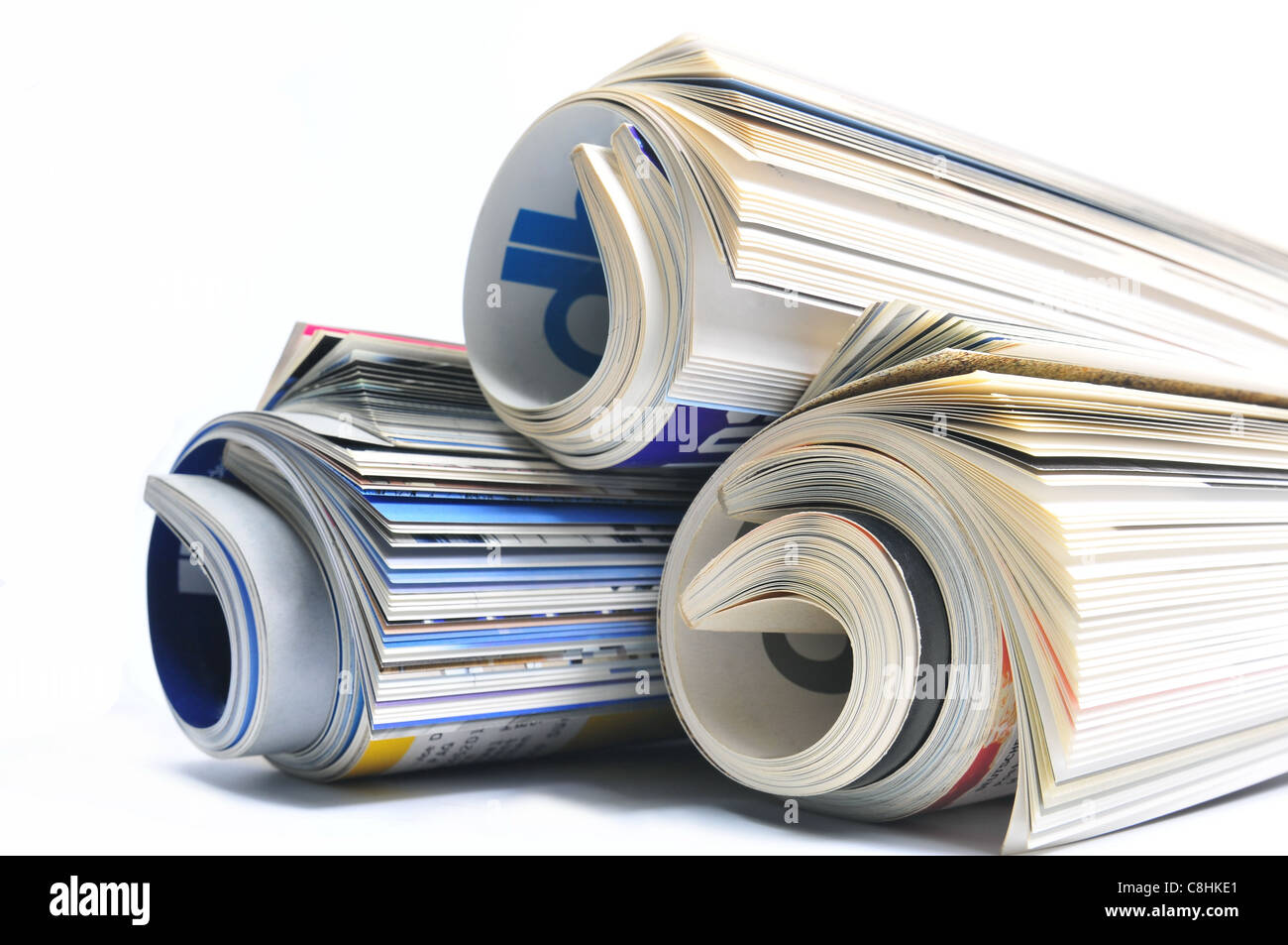 Three rolled up magazines on white background Stock Photo - Alamy
