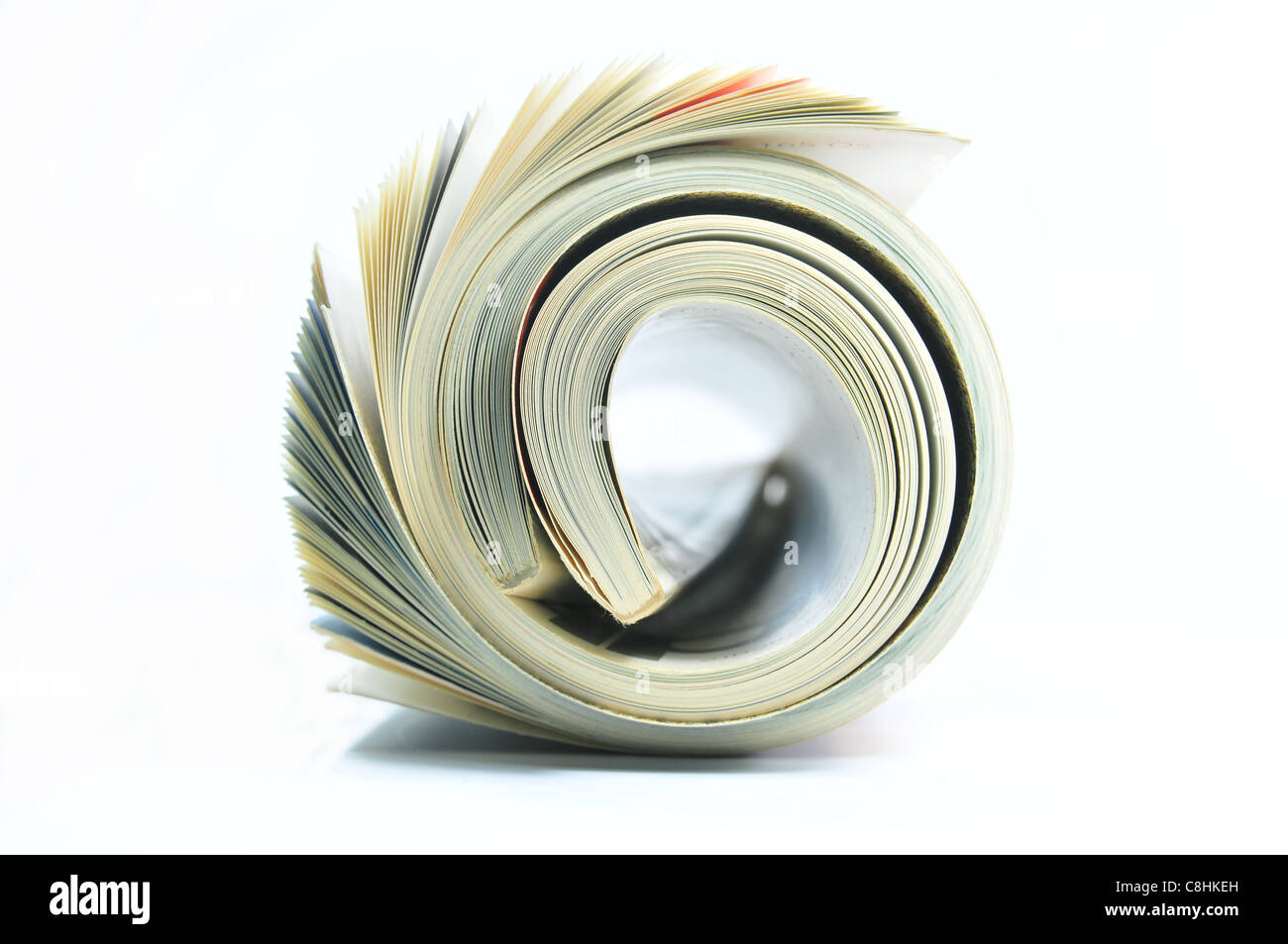 Rolled up magazine on white background Stock Photo - Alamy