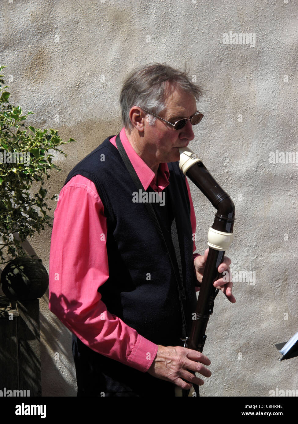 Man playing a musical wind instrument in the courtyard of Plas Mawr in ...