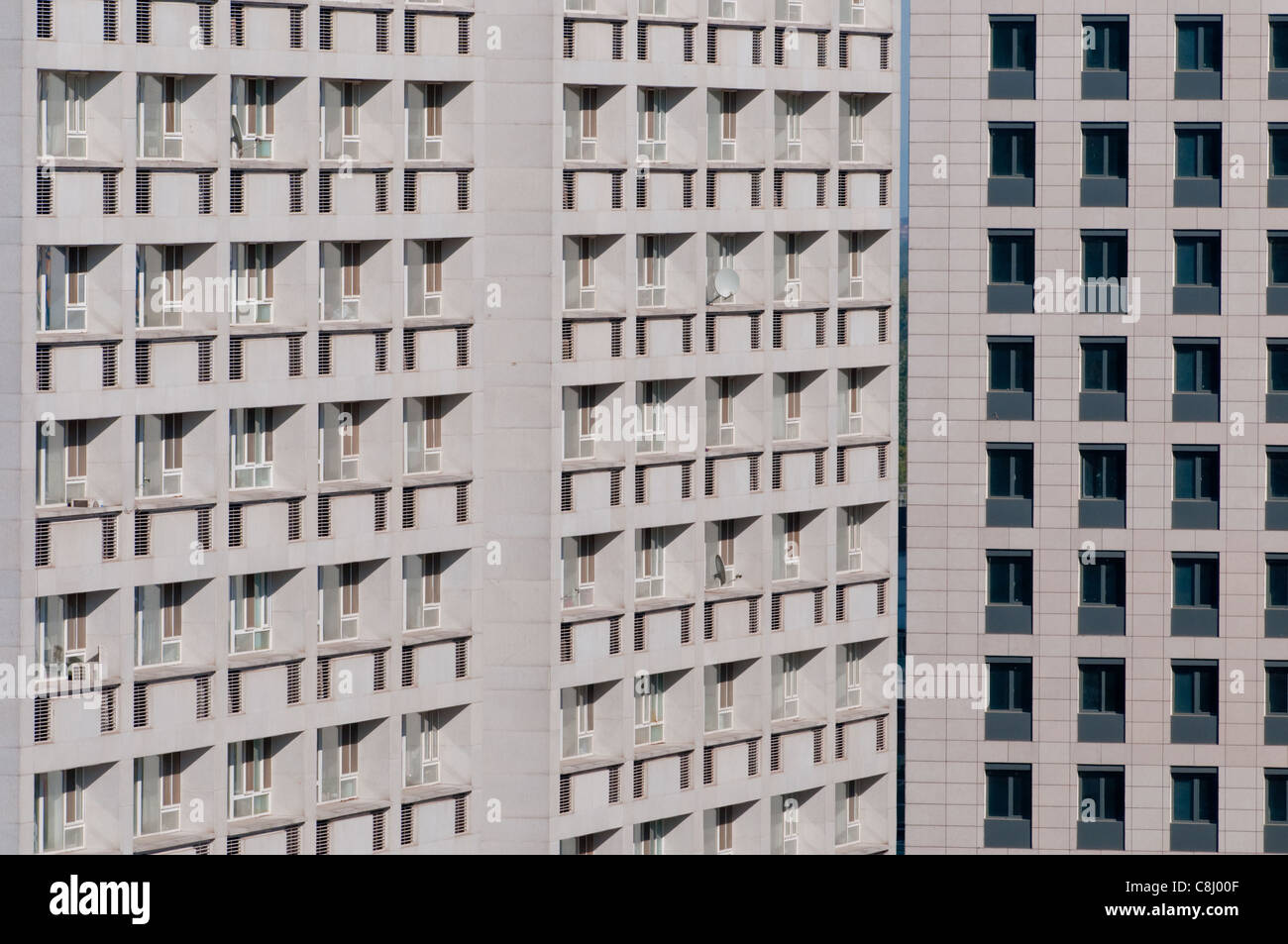 A woman glances out of a window of an old apartment block in Chaoyang ...