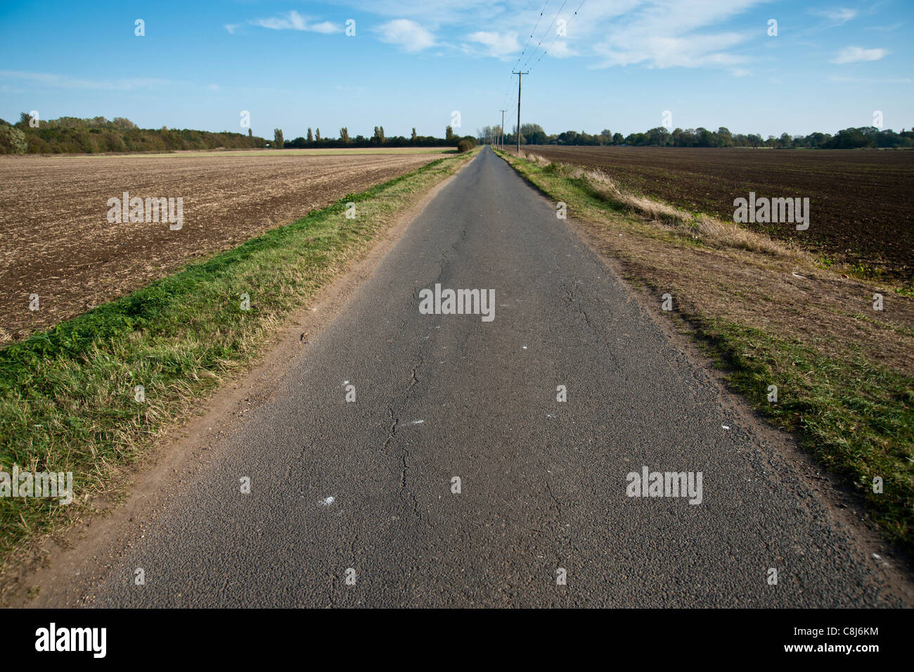 An open, empty Fen road with lines converging on the horizon ...