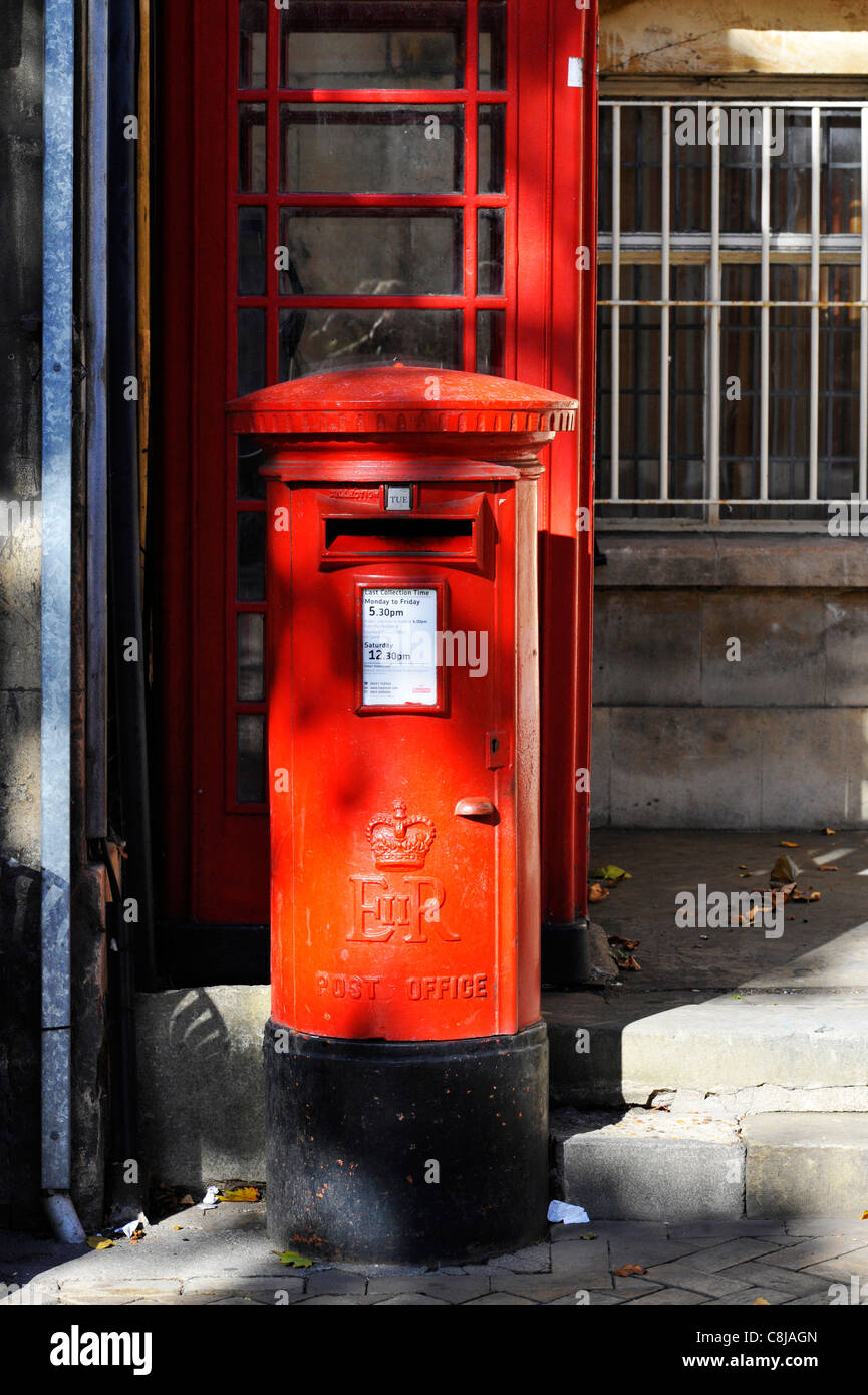 A red post box in front of a red telephone box in Stamford, England ...