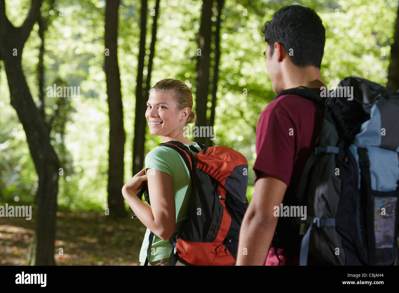 young man and woman during hiking excursion, with woman looking over ...